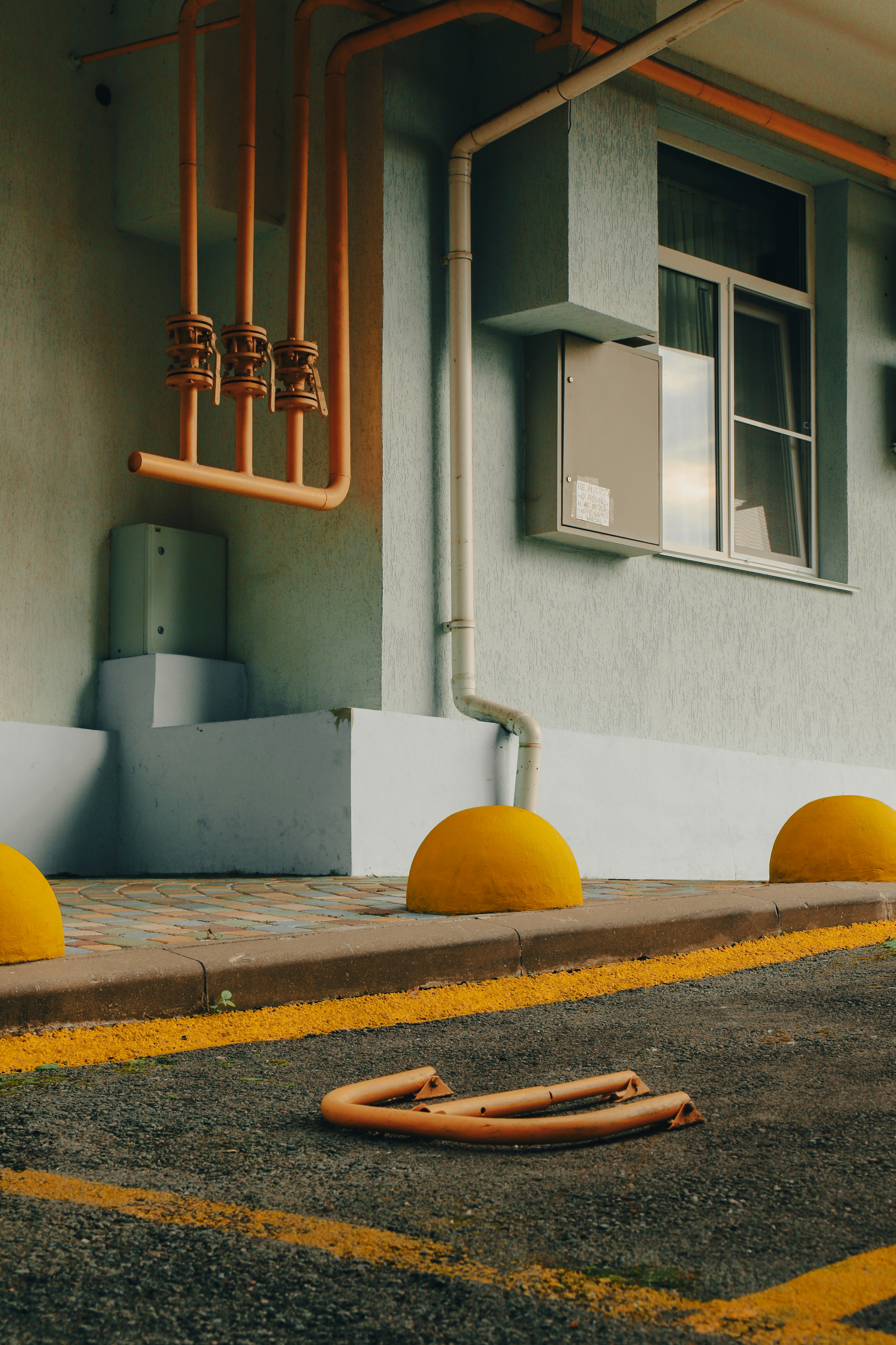 Coiled Orange Hose Anchors a Teal Industrial Facade