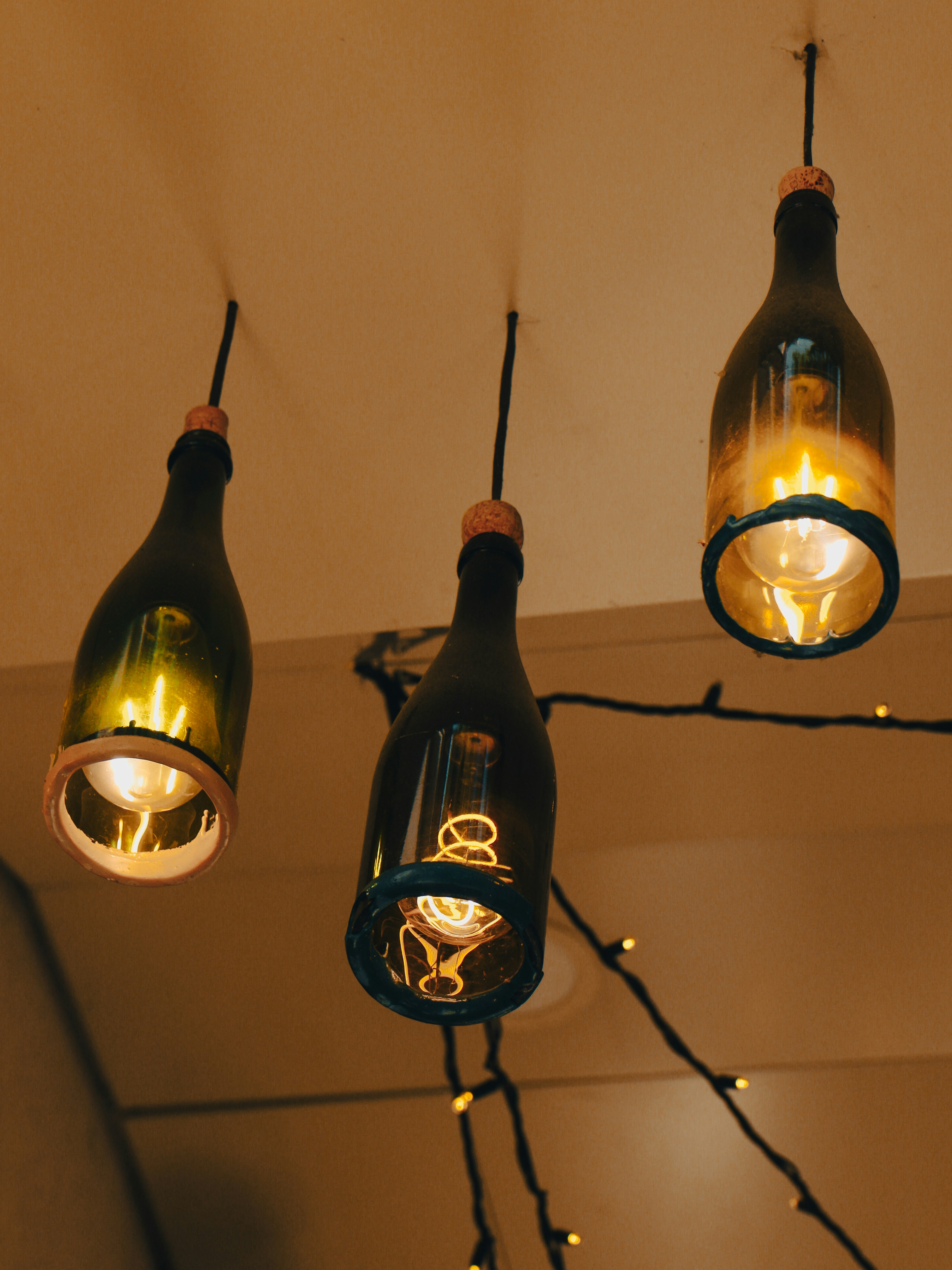 Three wine bottle lights hanging from a ceiling photo – Free Light ...