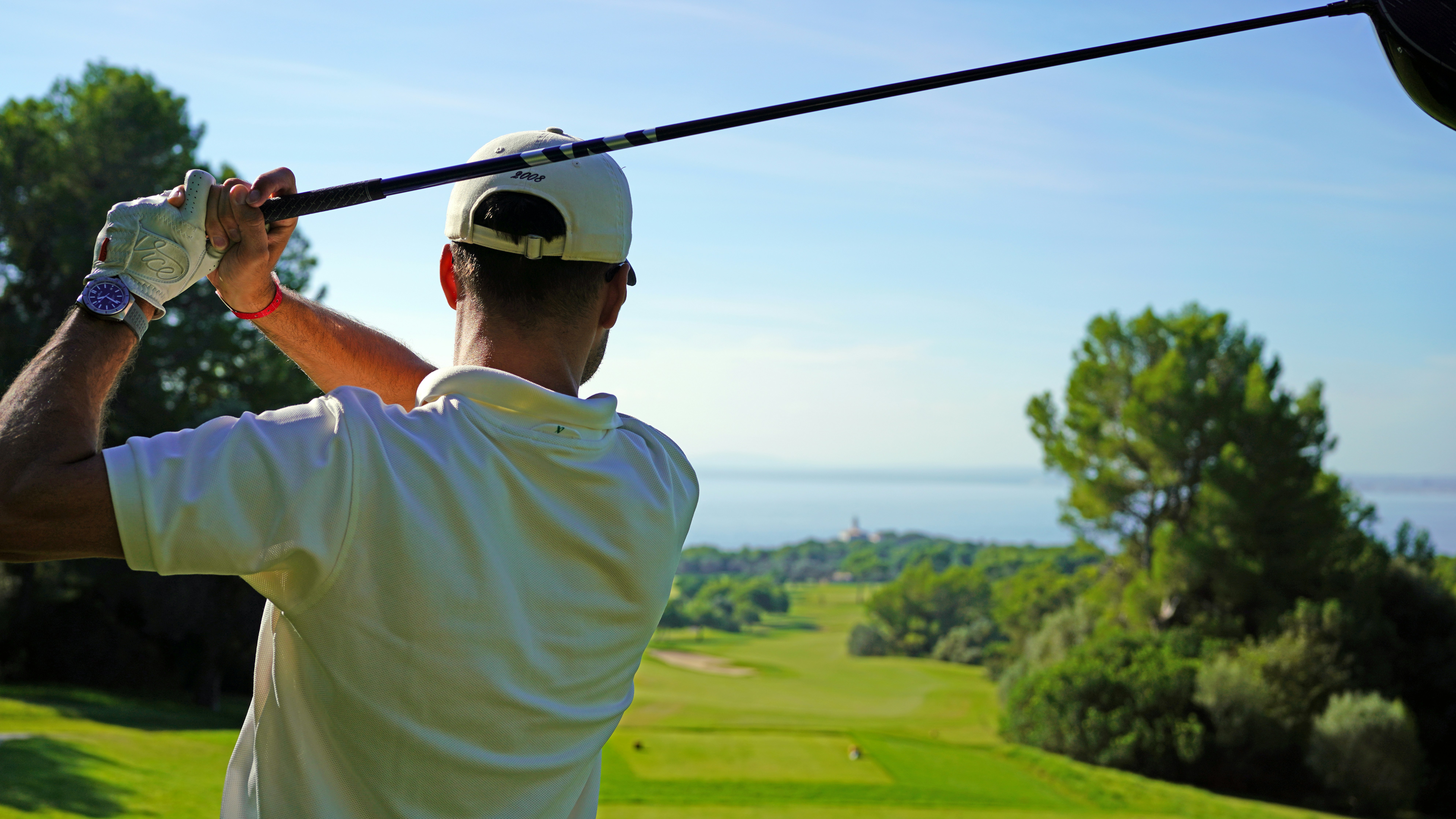 A man swinging a golf club on a golf course photo – Free Club de golf ...