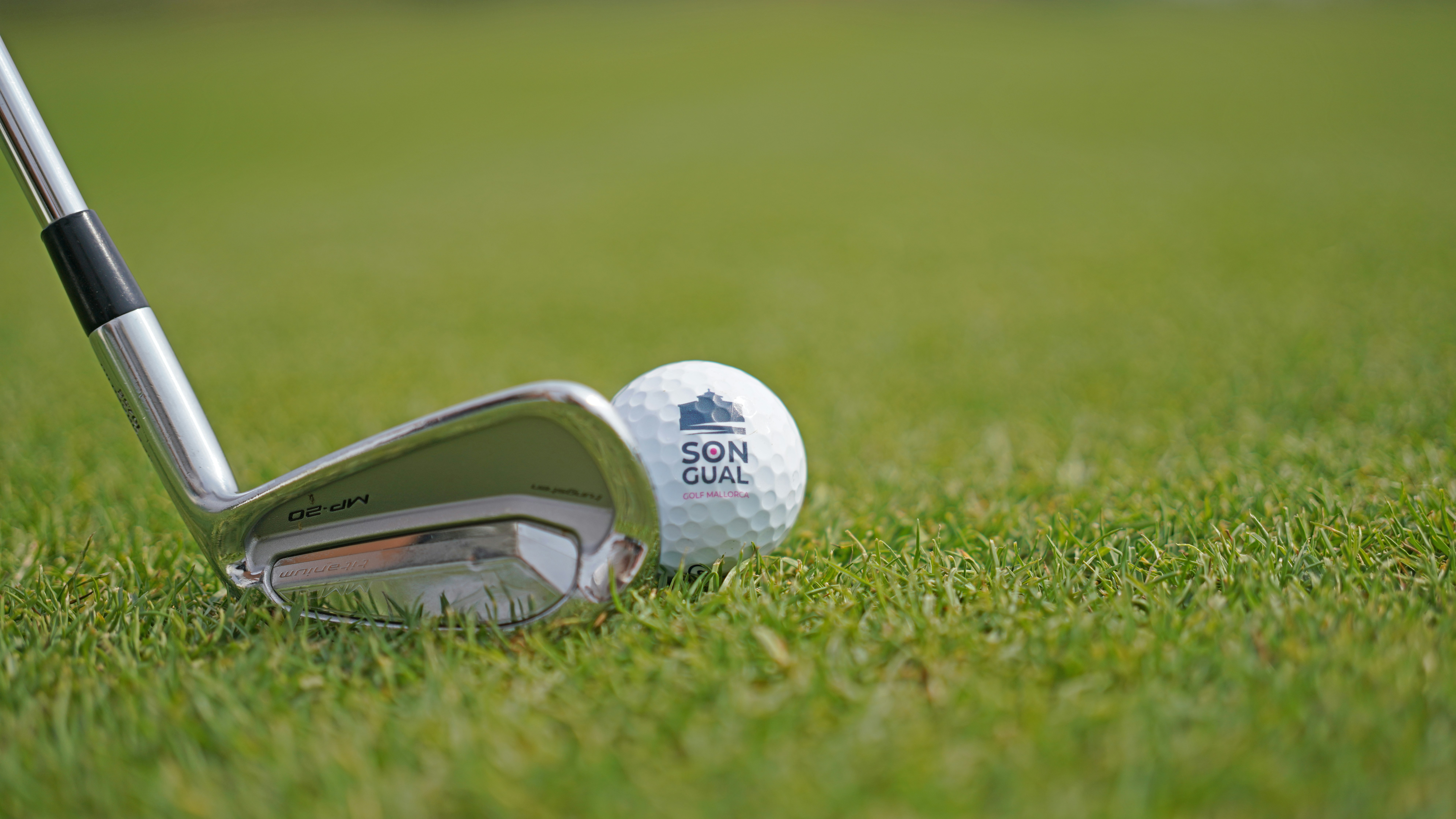 A close up of a golf club and a golf ball