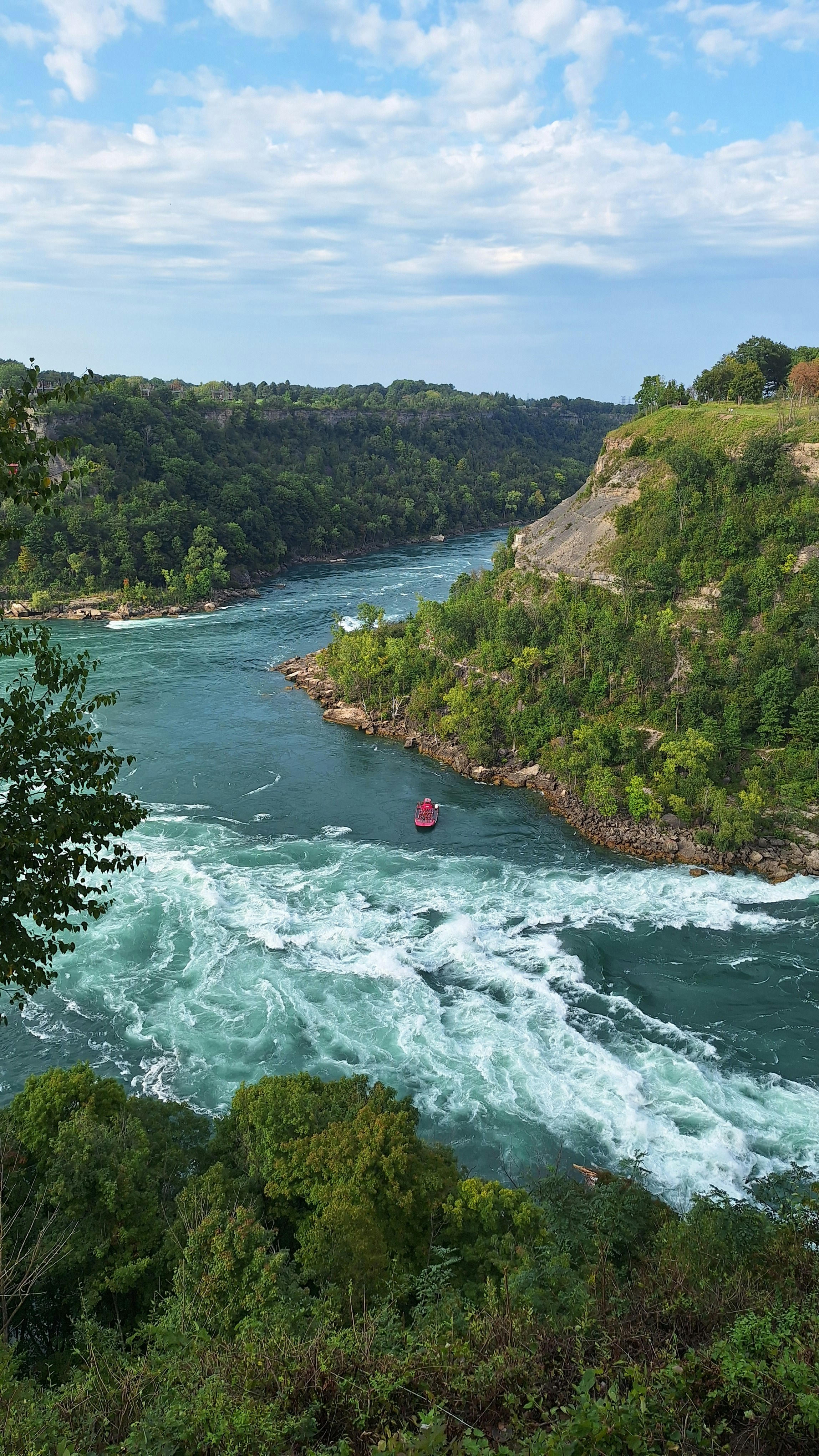 Red Boat Navigates a Verdant Gorge