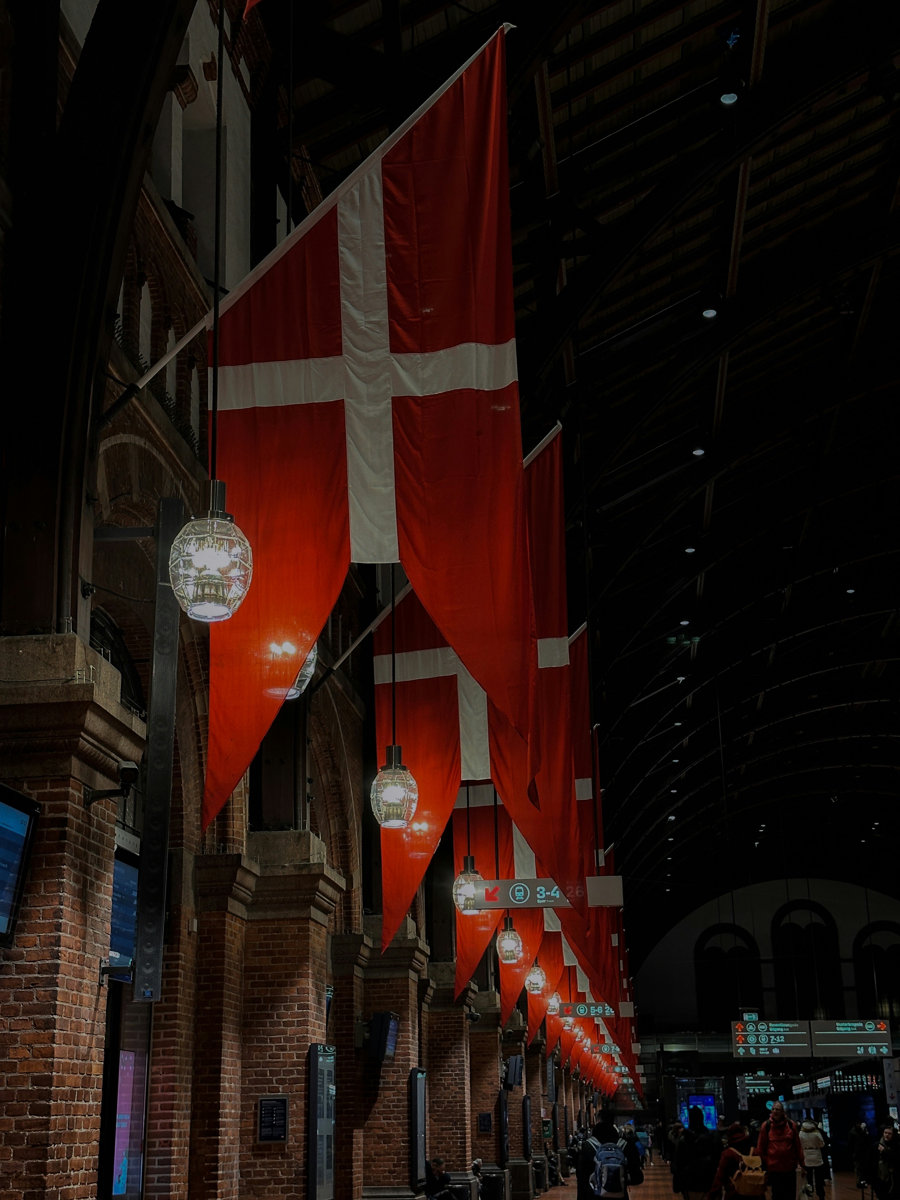 A group of flags hanging from the ceiling of a building photo – Free ...