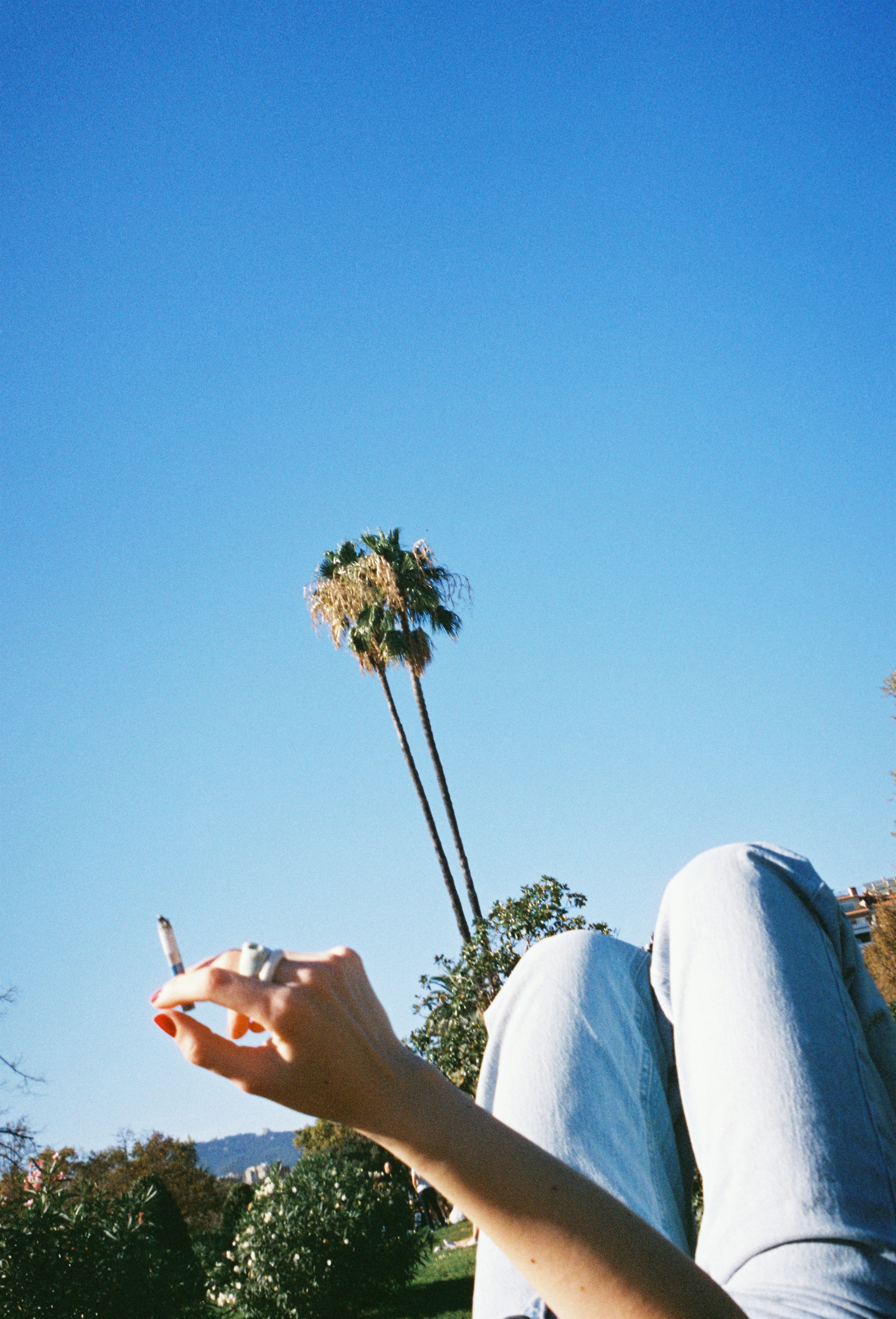 A woman sitting on the ground smoking a cigarette photo – Free ...