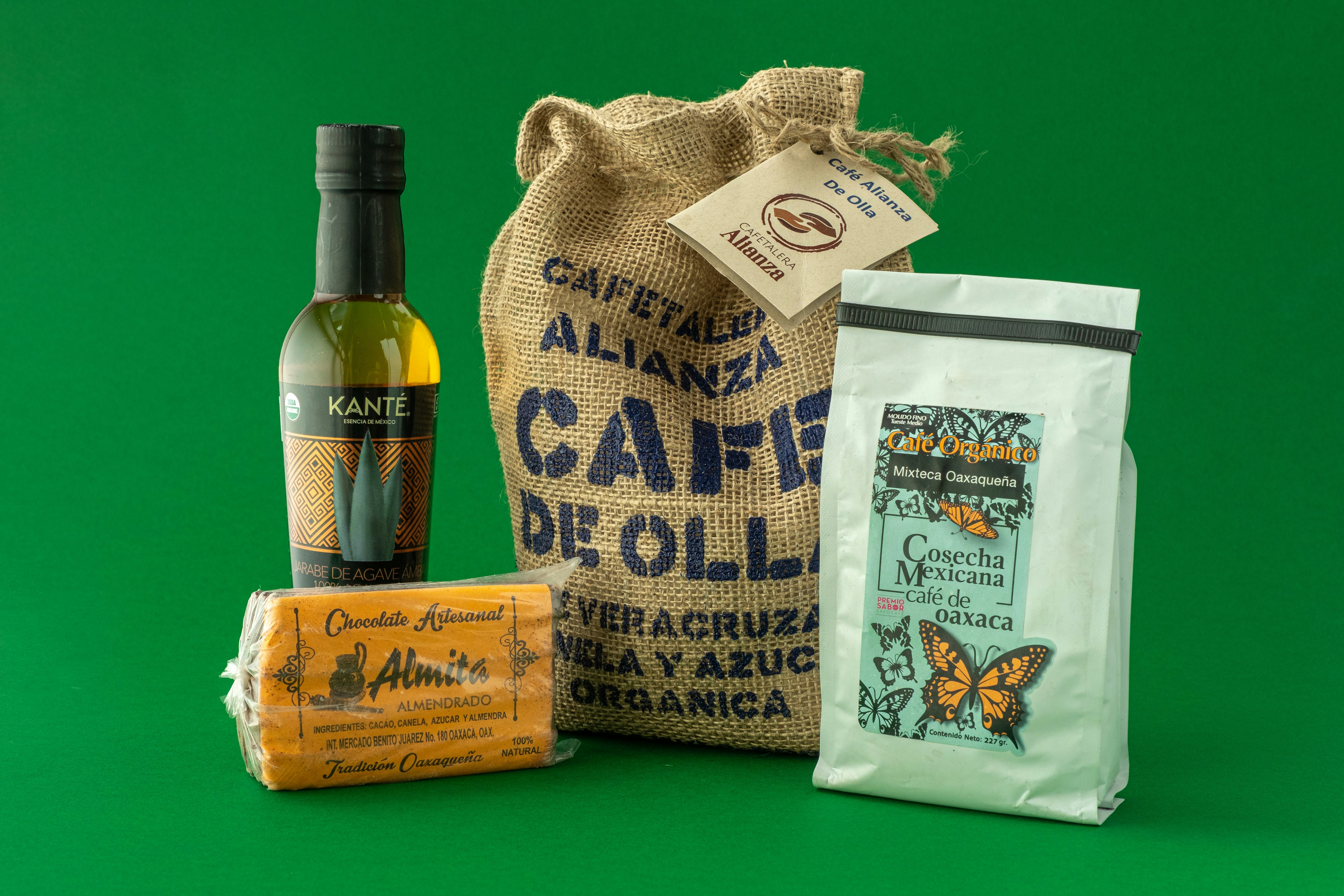 Collection of gourmet products including organic coffee, artisanal chocolate, and olive oil, arranged thoughtfully against a vibrant green backdrop.