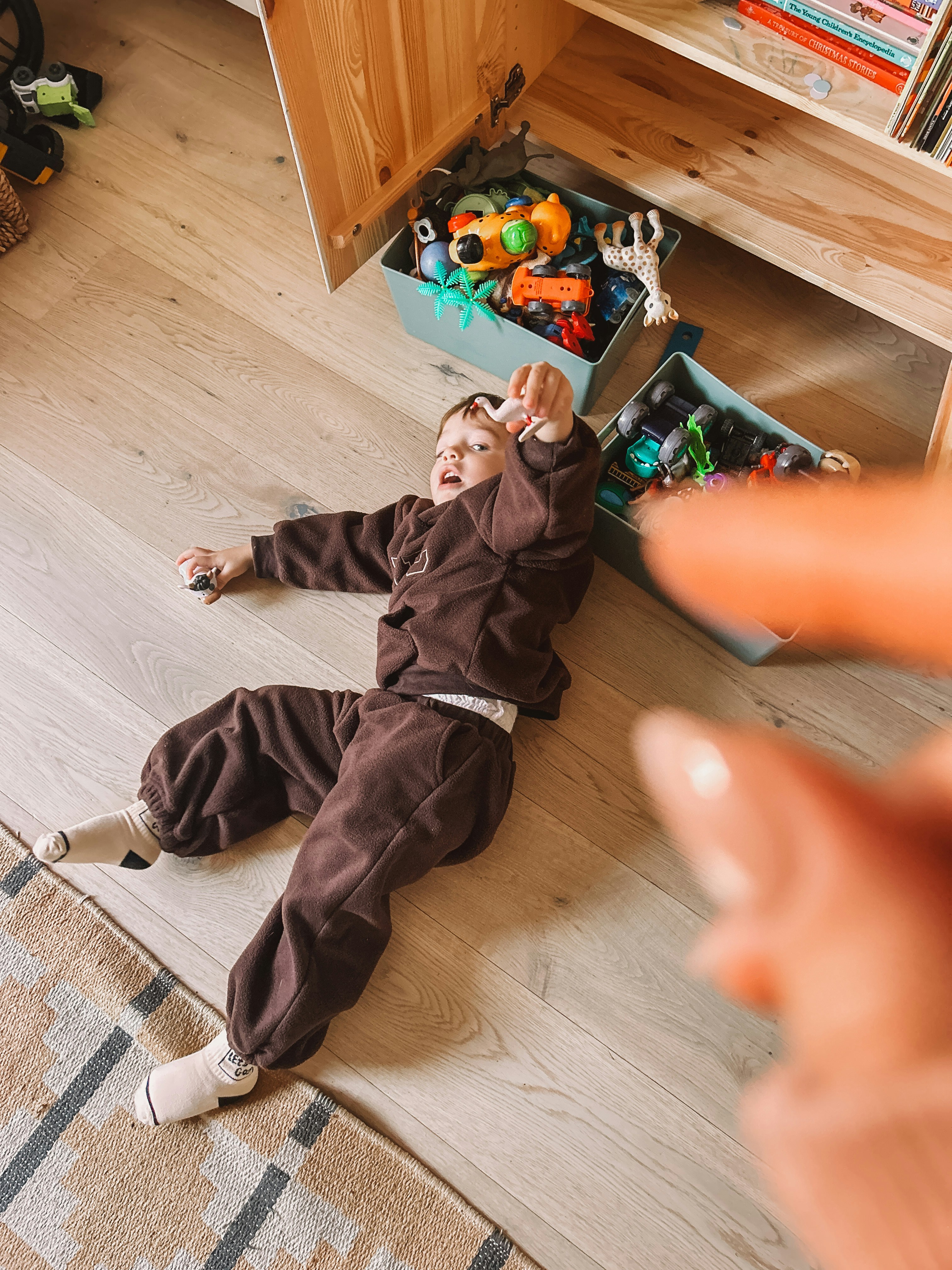 Lying Explorer: Reaching for a Moment Amid a Treasure Trove of Toys