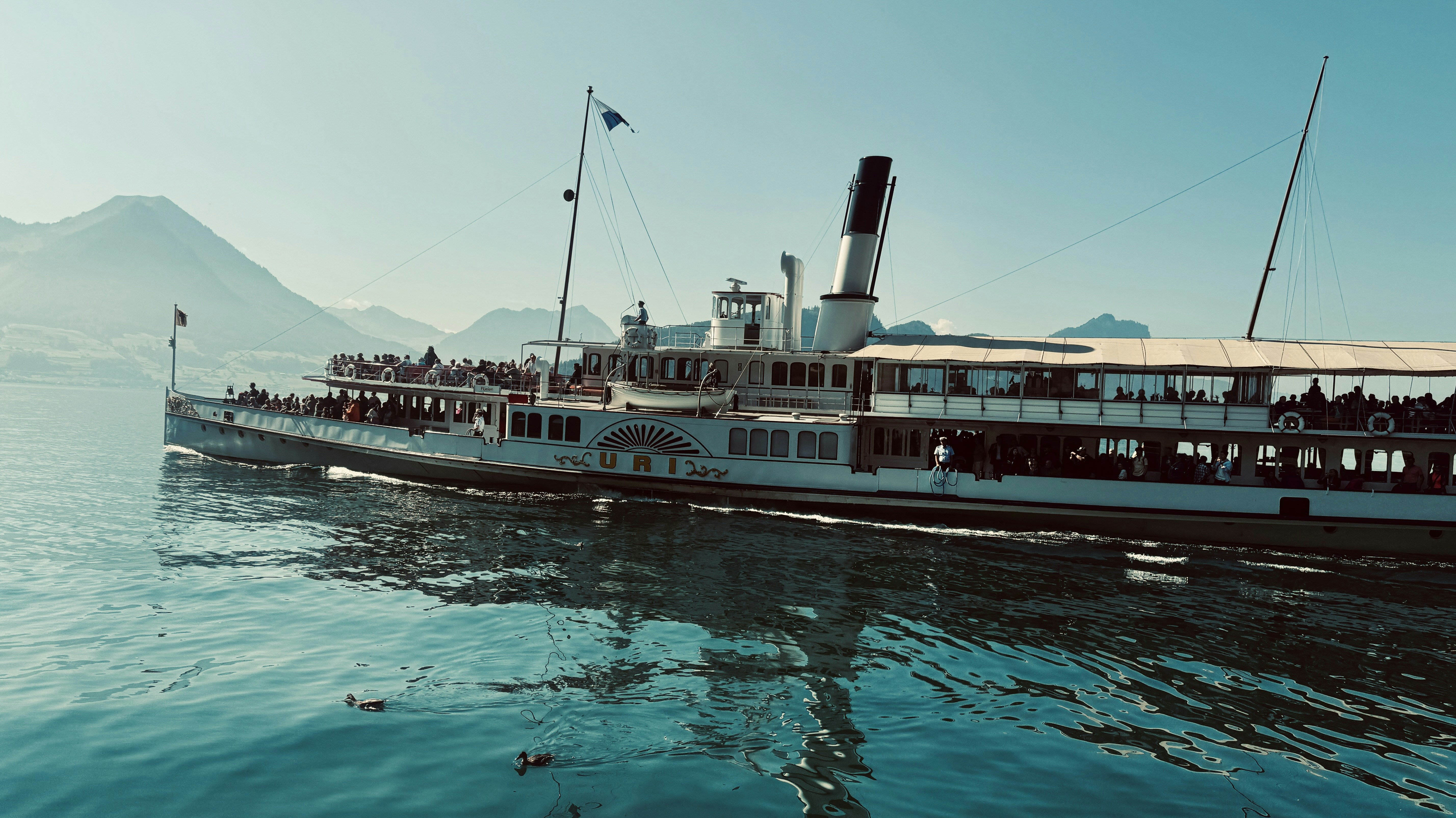 Steamship Traverses a Glassy Lake Beneath Alpine Peaks
