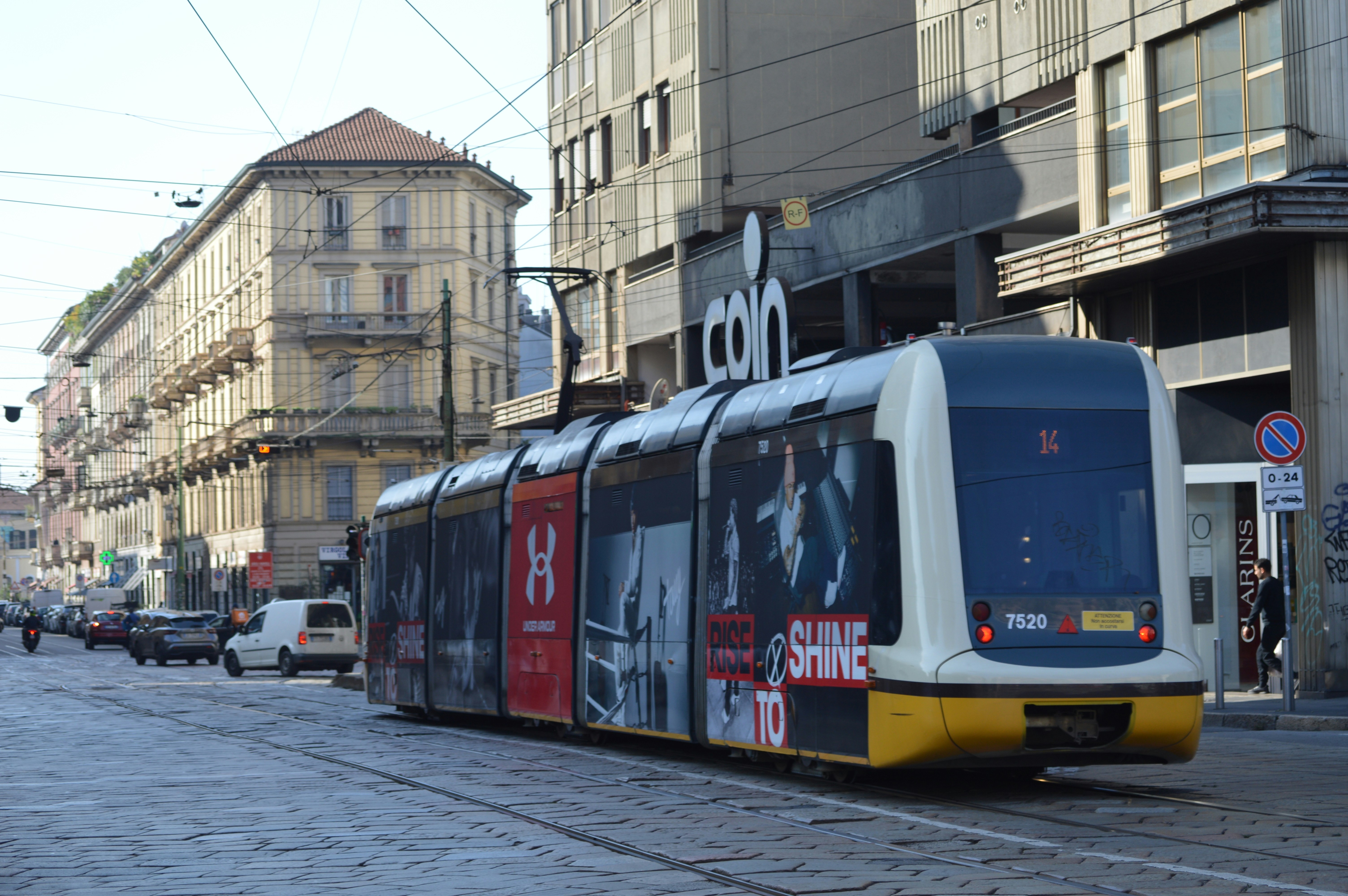 Blue-Accent Tram Glides Through a Storied City Block
