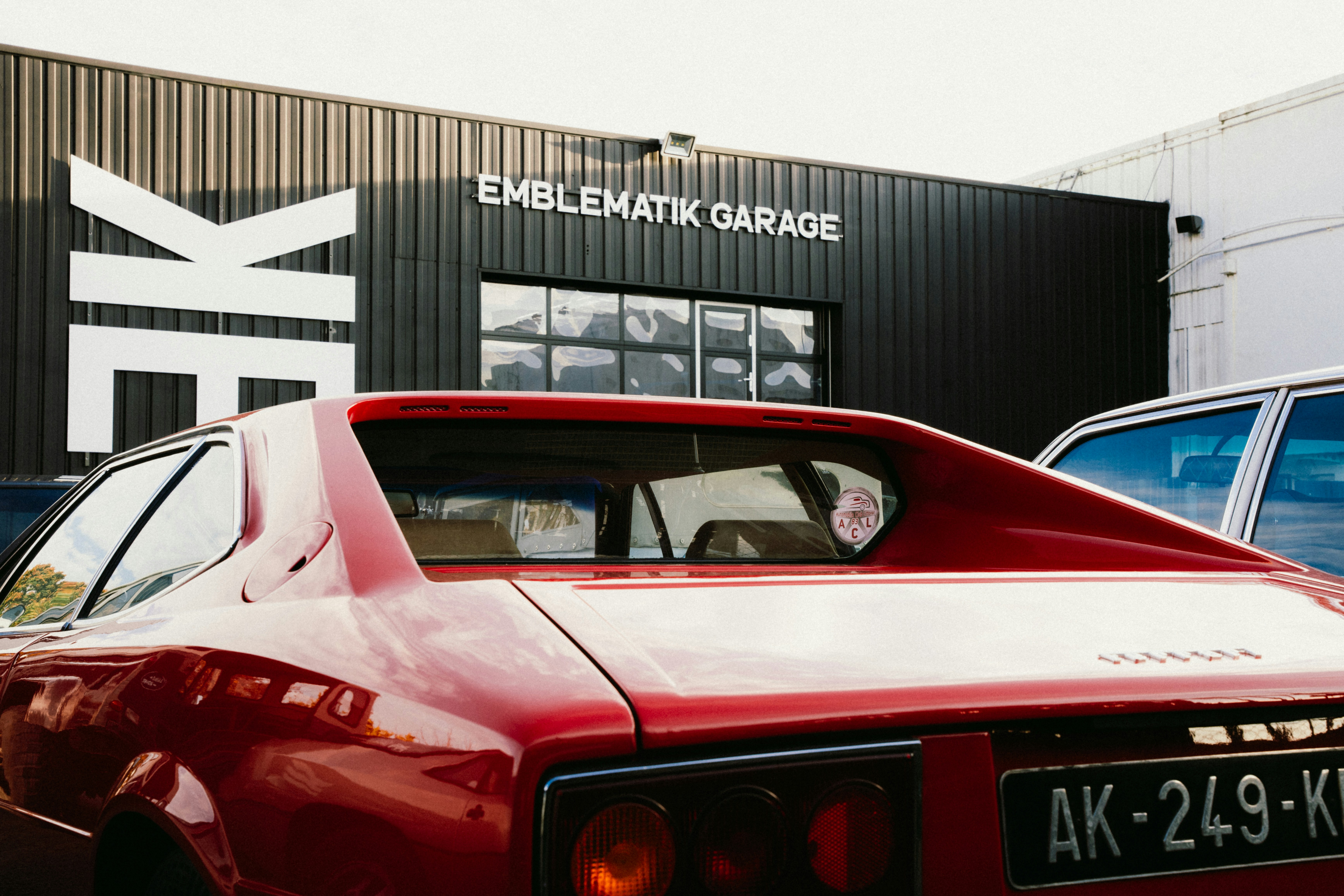 Red Vintage Coupe Framed by Emblematic Garage