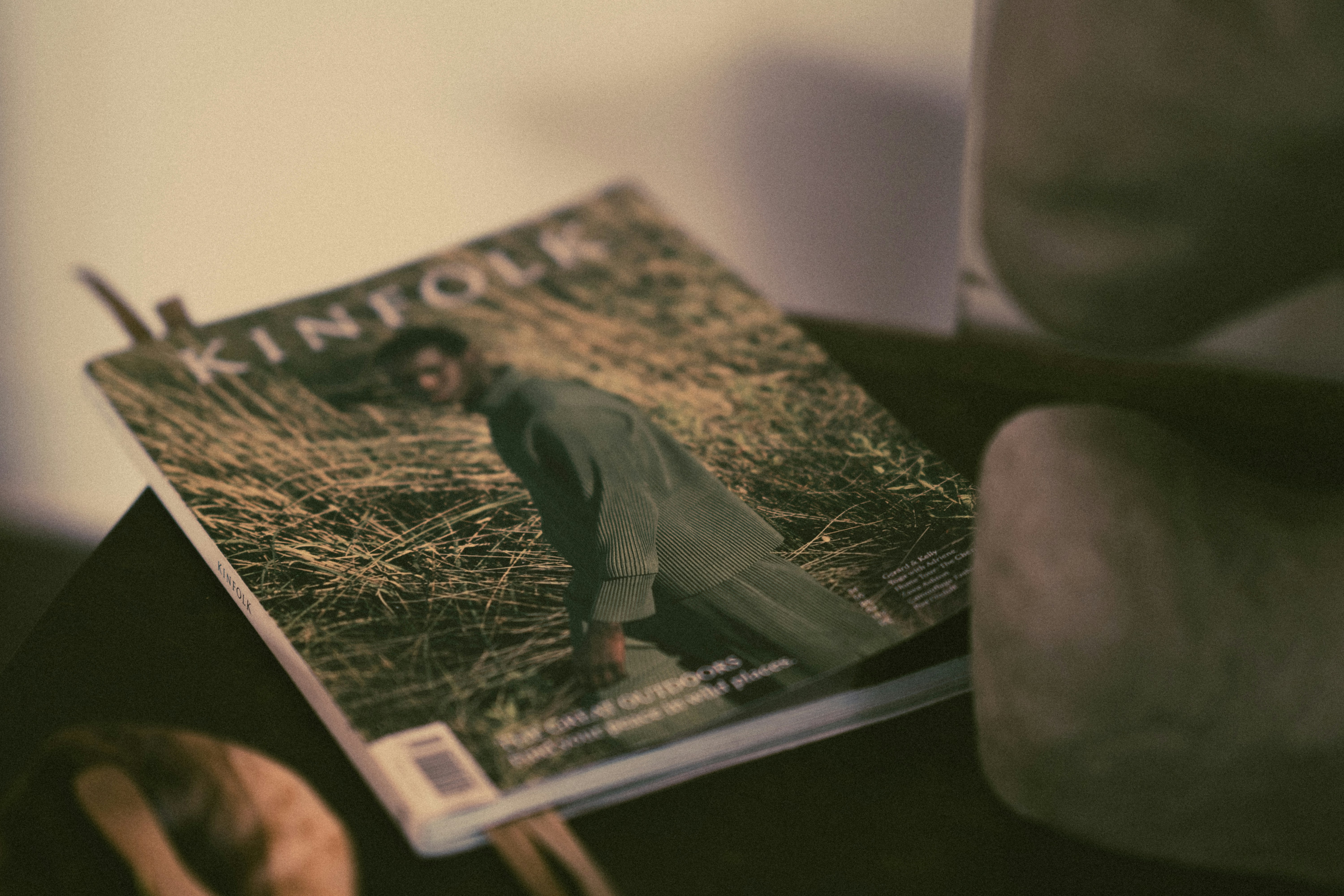 Magazine on a table under soft lighting, highlighting its cover and surrounding textures.