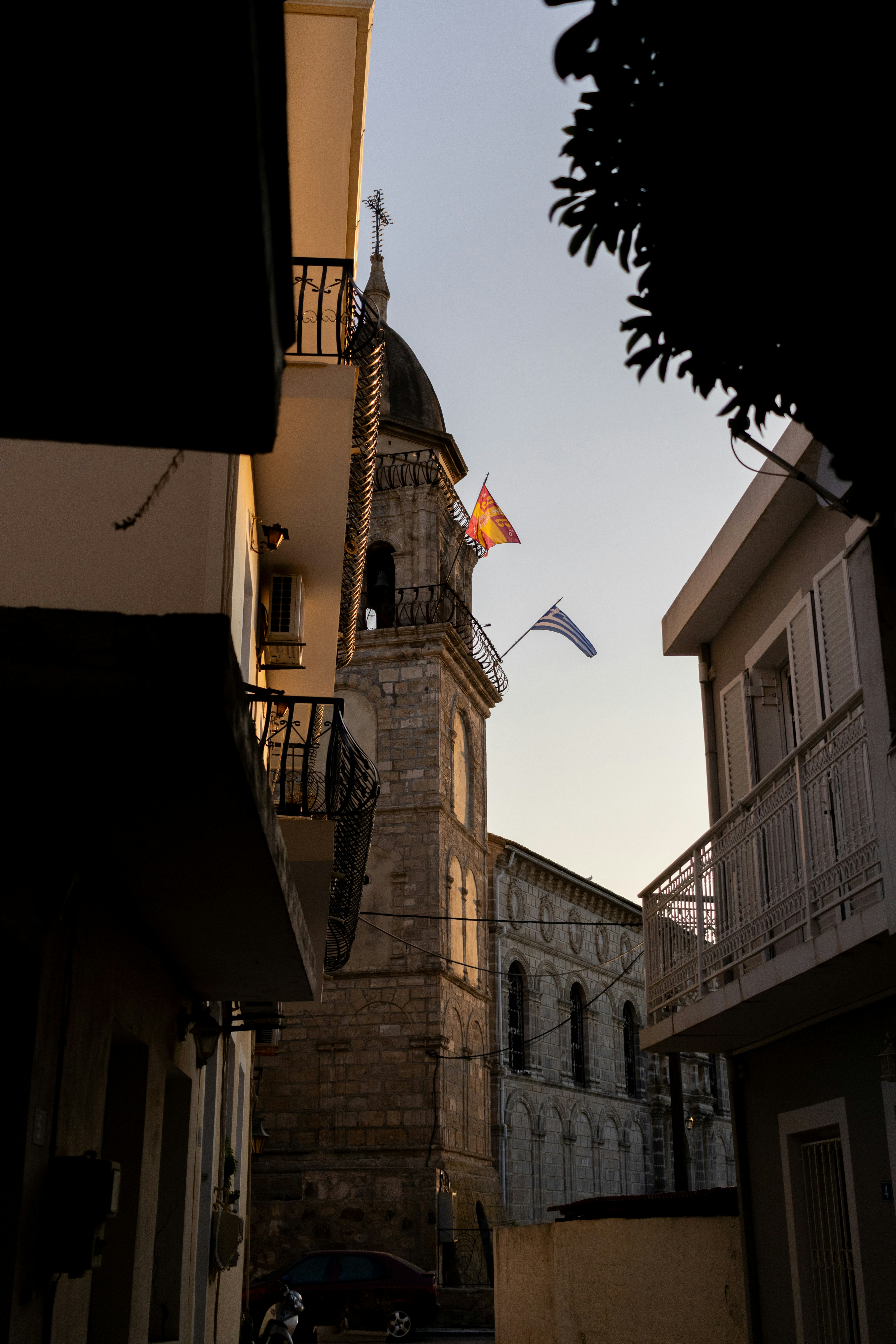 Dusk Bell Tower Framed by Narrow, Sunlit Alleys