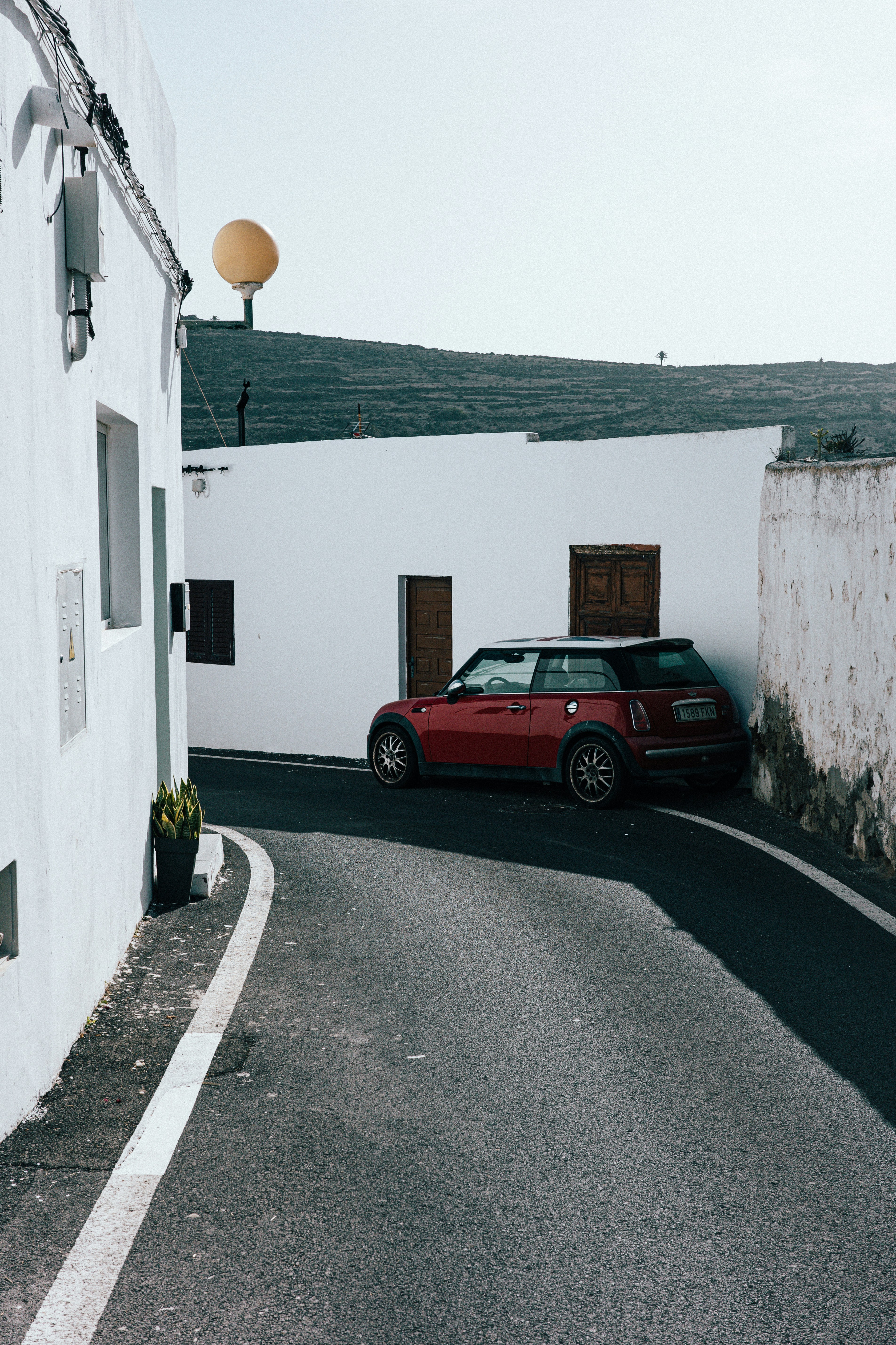 Crimson Mini on a sunlit Cycladic lane