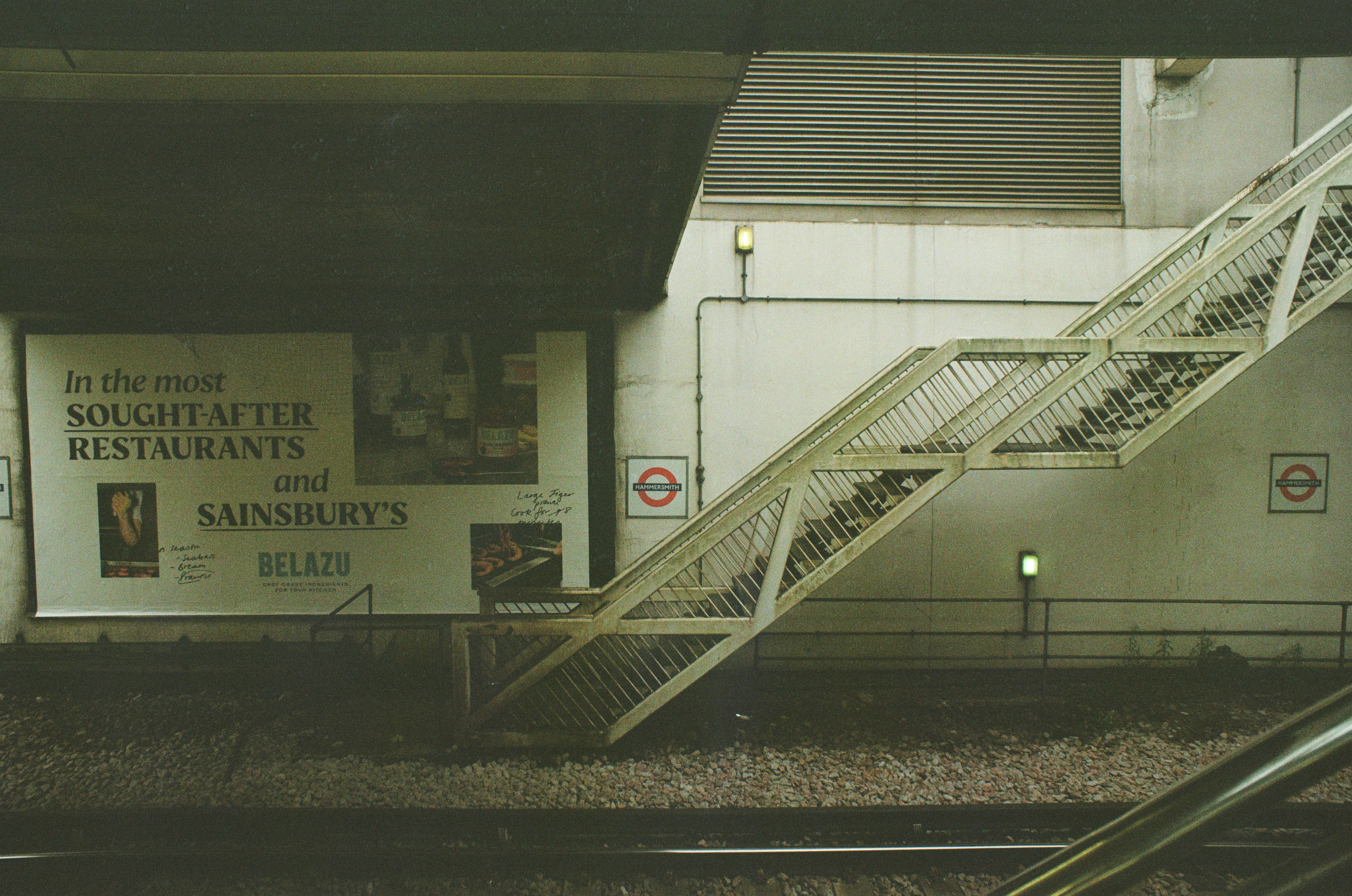 A train station with stairs leading up to the platform photo – Free ...