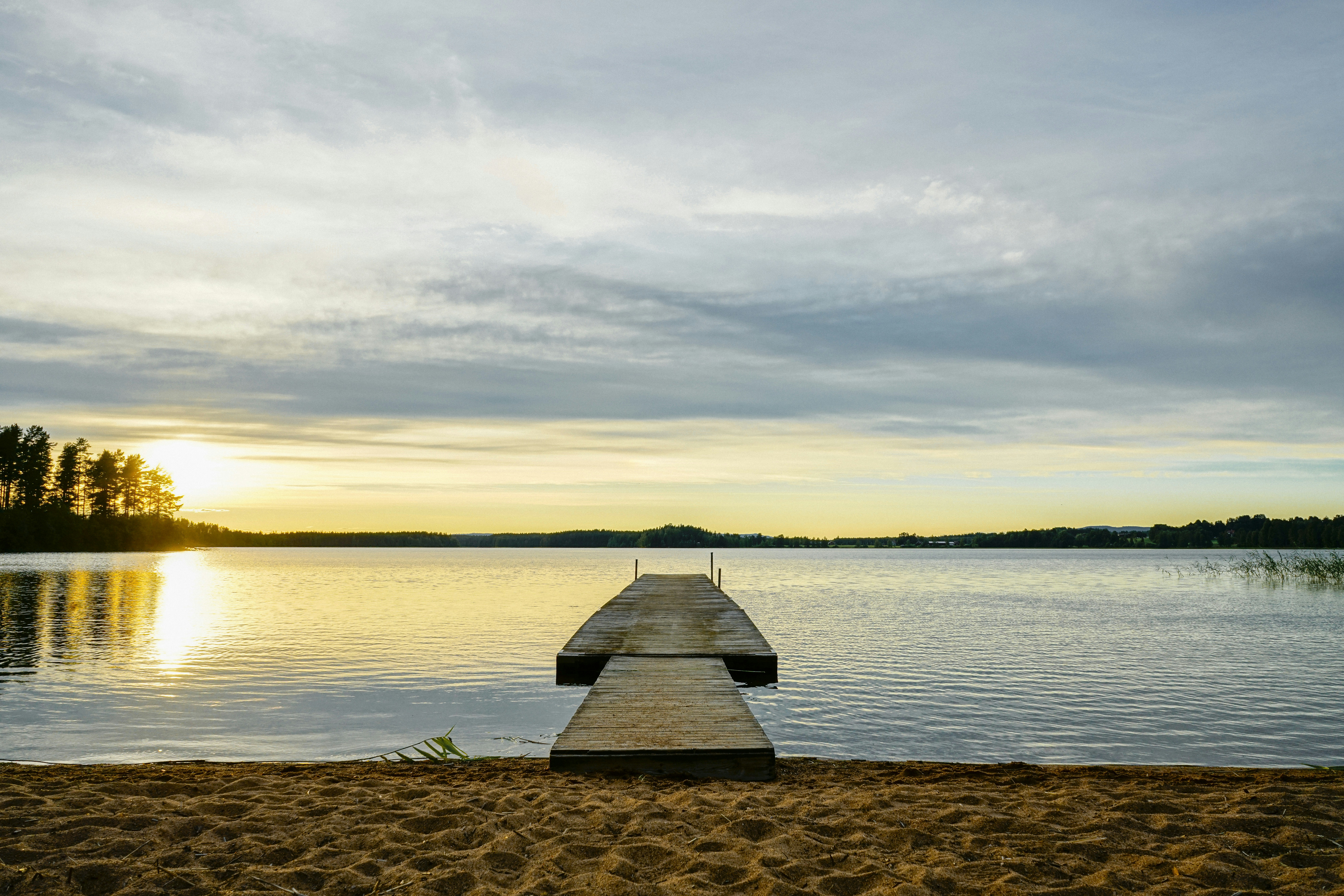 A wooden dock sitting on top of a sandy beach photo – Free Beach Image ...