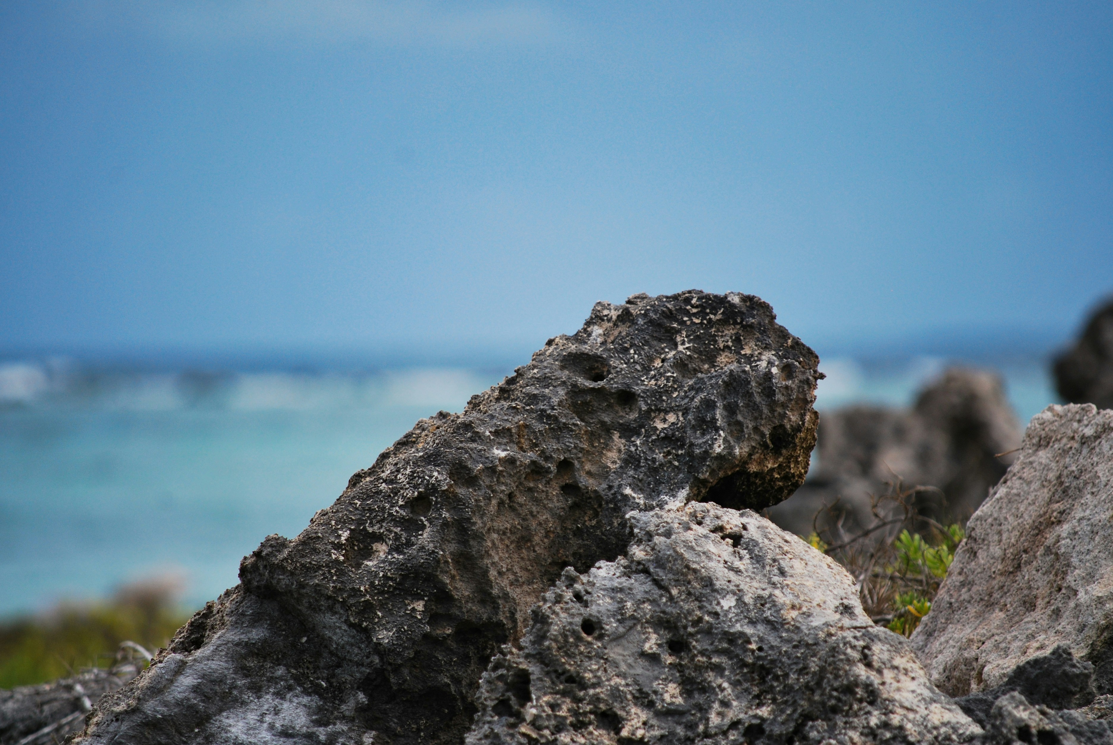 Weathered shoreline sentinels: jagged rocks guarding a tranquil sea