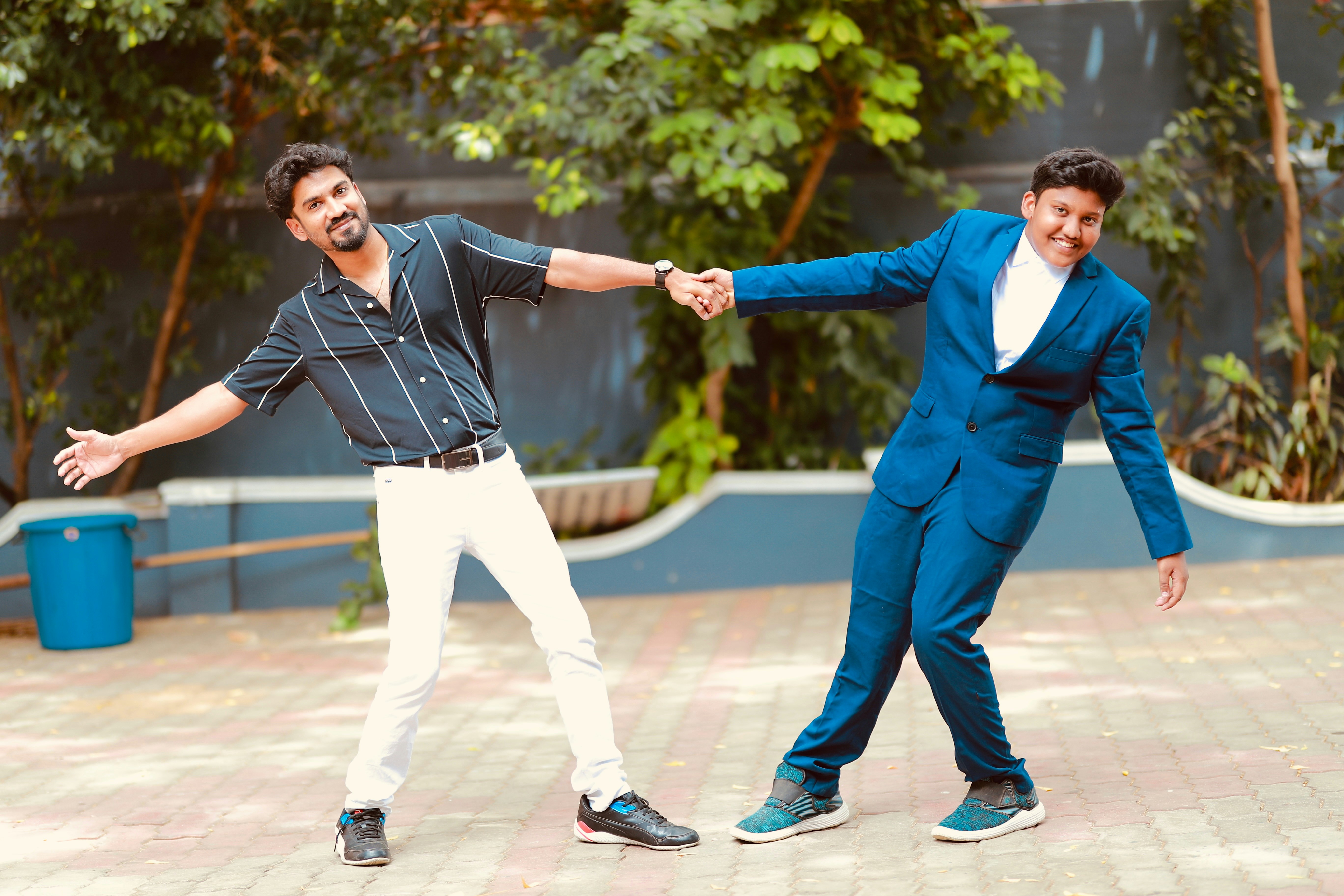 Two men in blue jackets and white pants are dancing photo – Free Hand ...