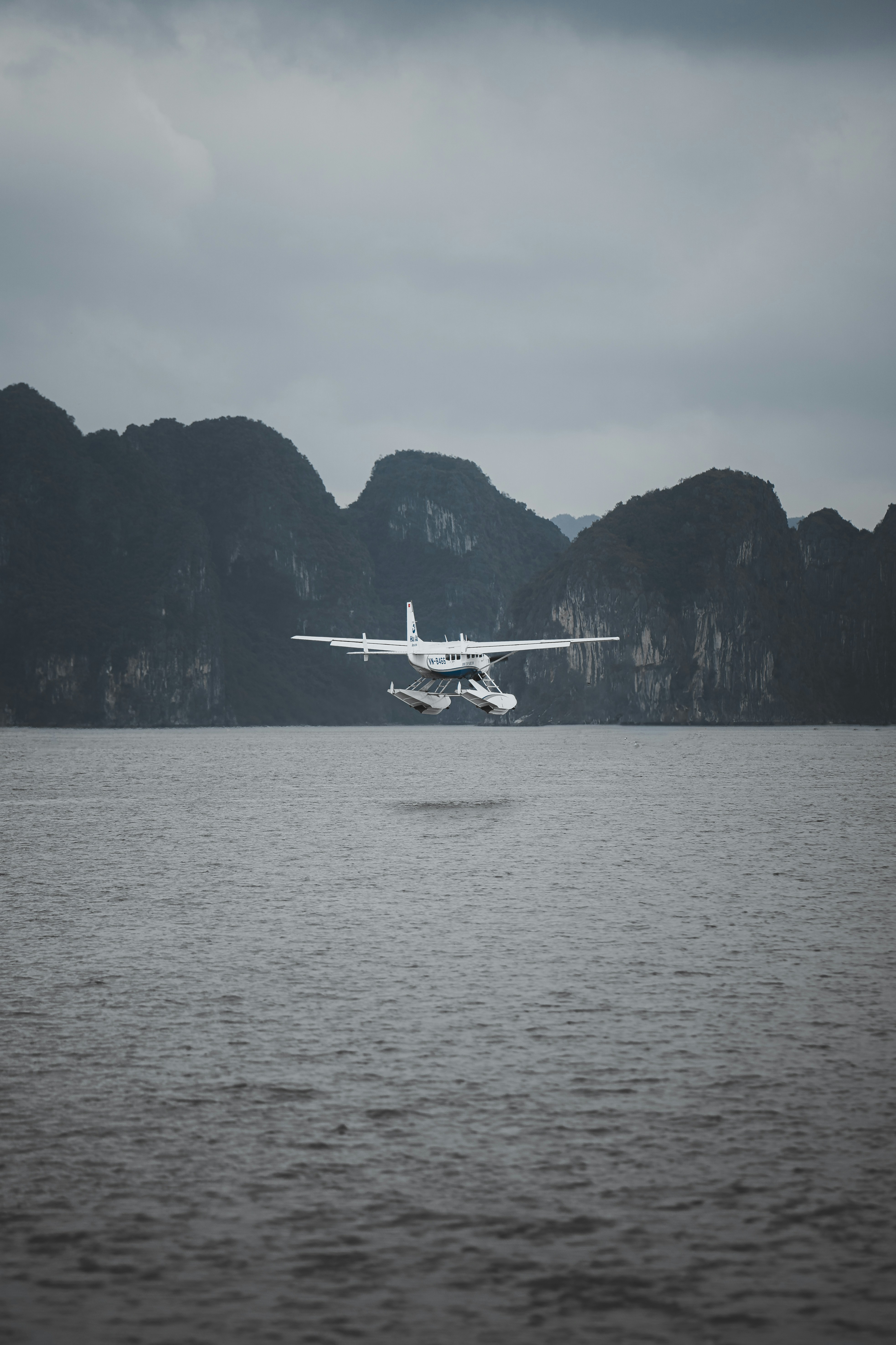 A plane flying low over a body of water photo – Free Landing Image on ...