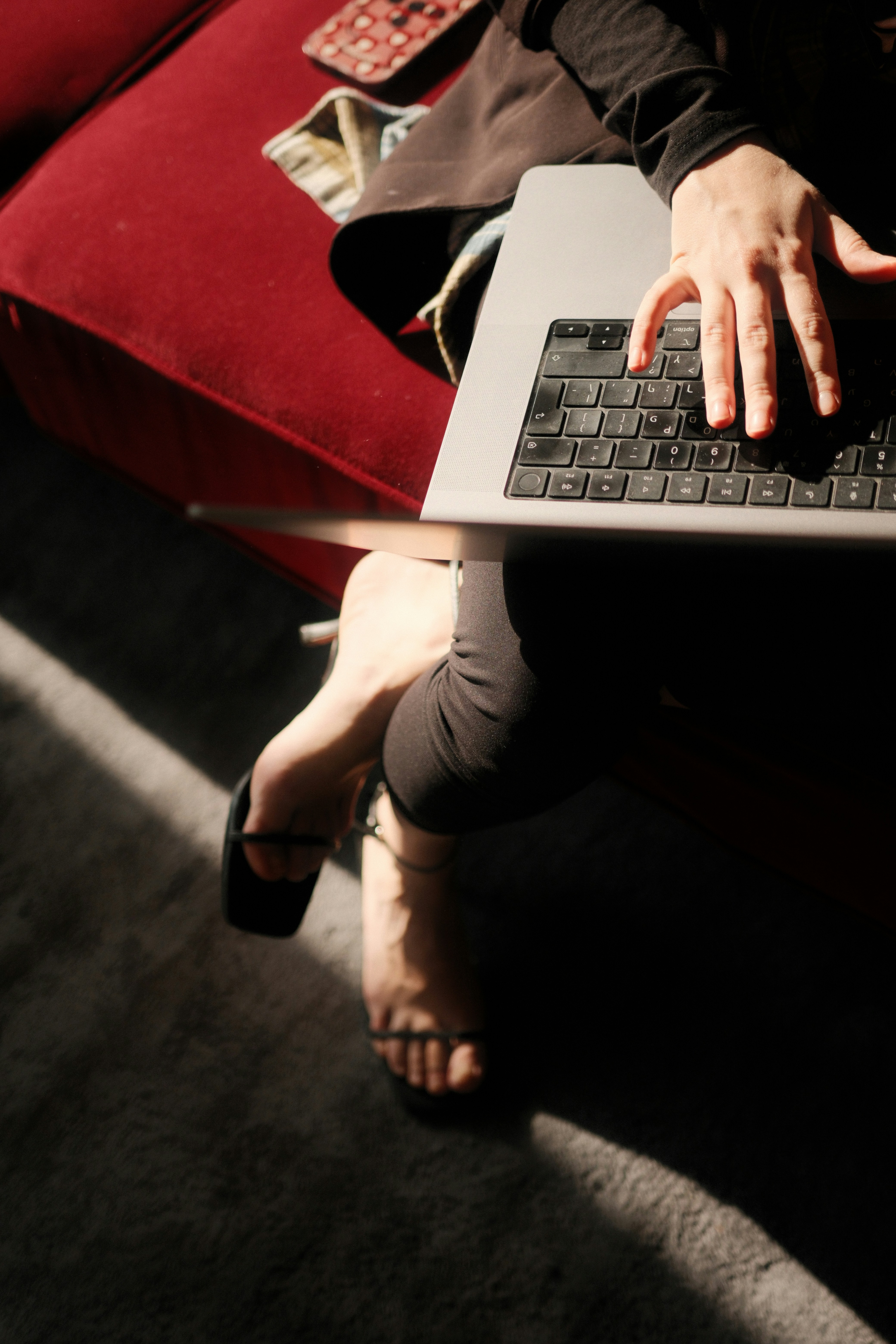 A woman sitting on a couch using a laptop computer photo – Free ...