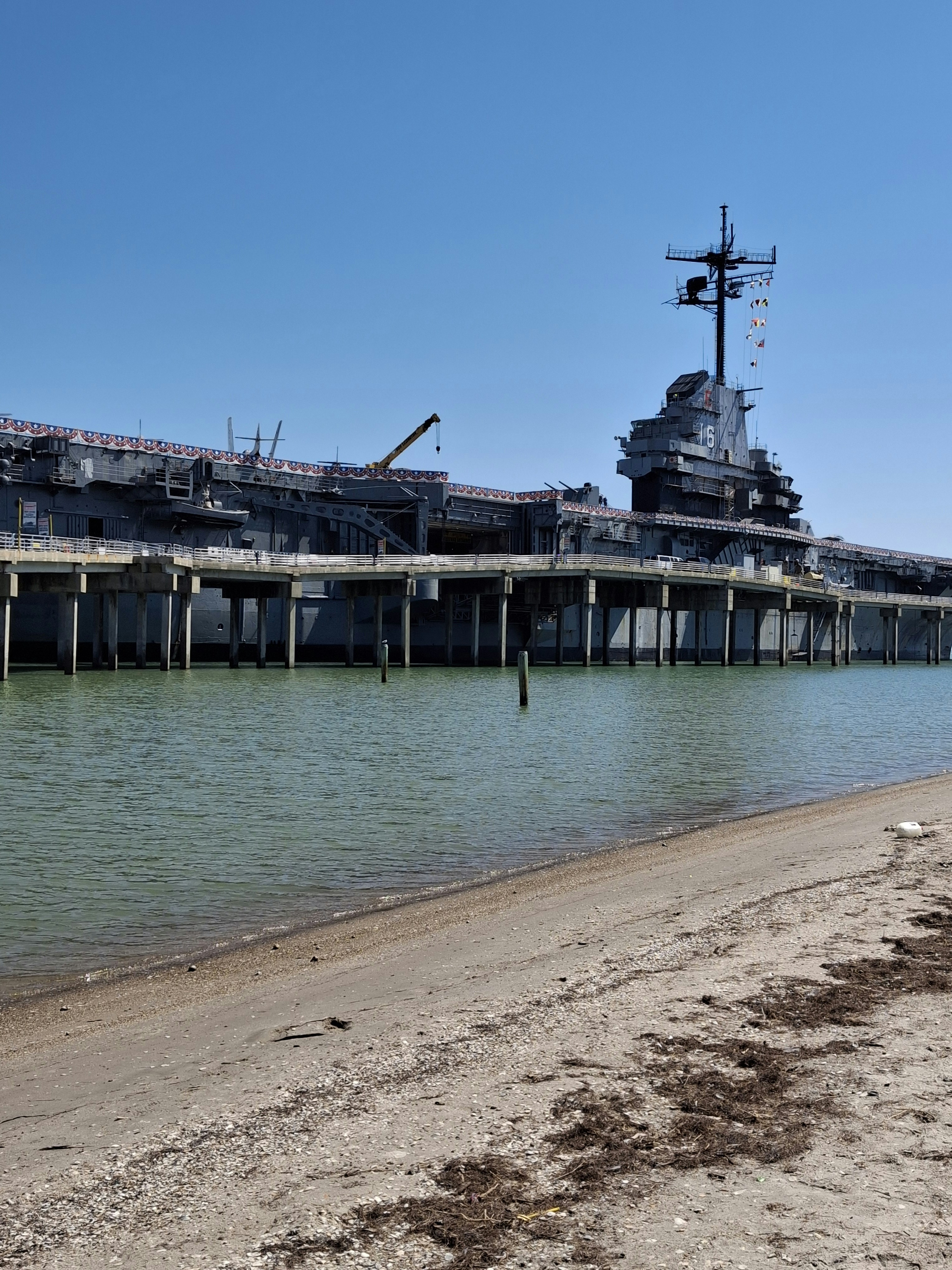 Decked Carrier at Dusk: An Industrial Horizon by the Shore