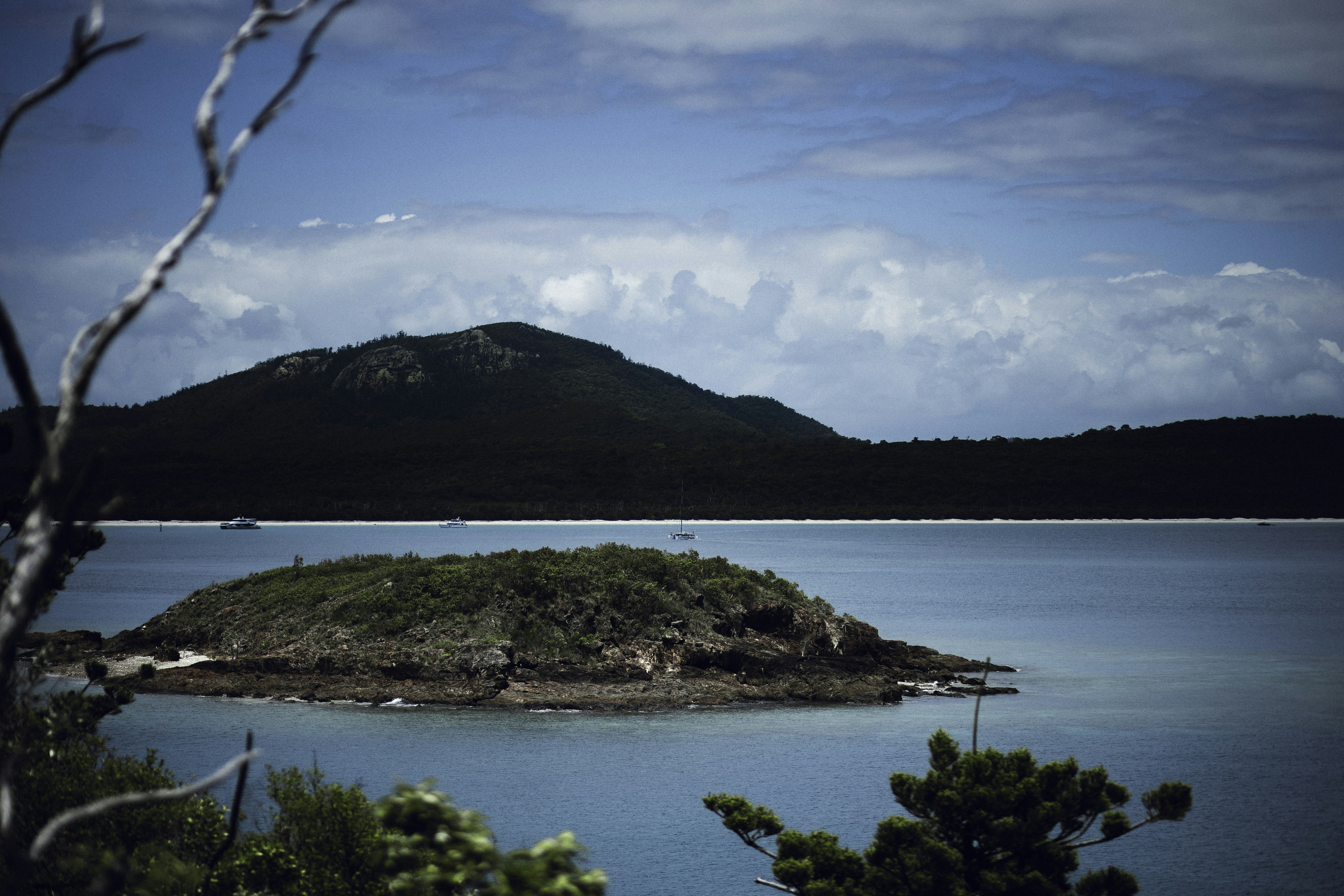 Islet in a Glassy Channel Beneath a Cloud-Swept Sky