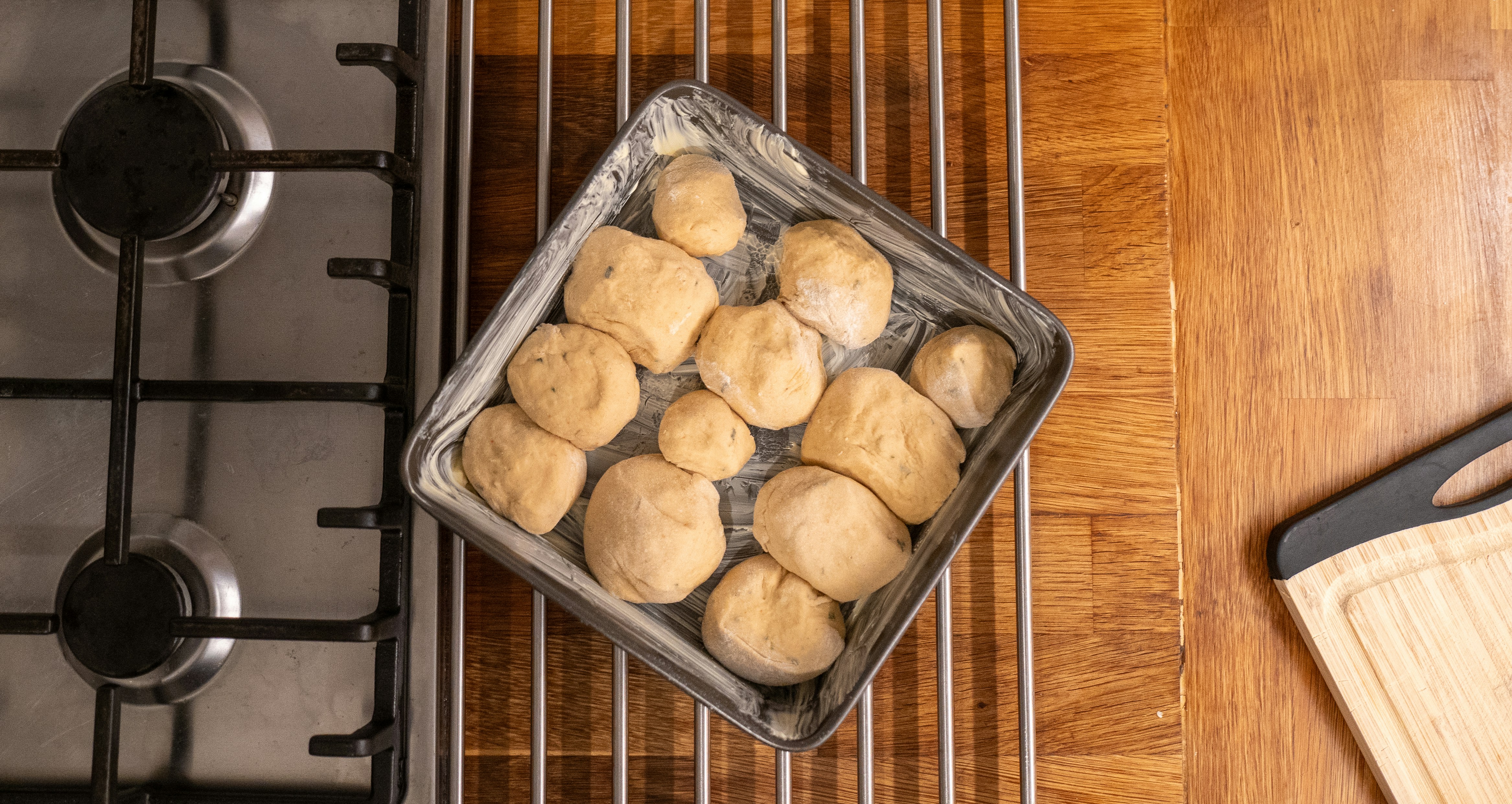 Copper-Warmed Dough Balls Rest on a Wire Rack Beside the Stove