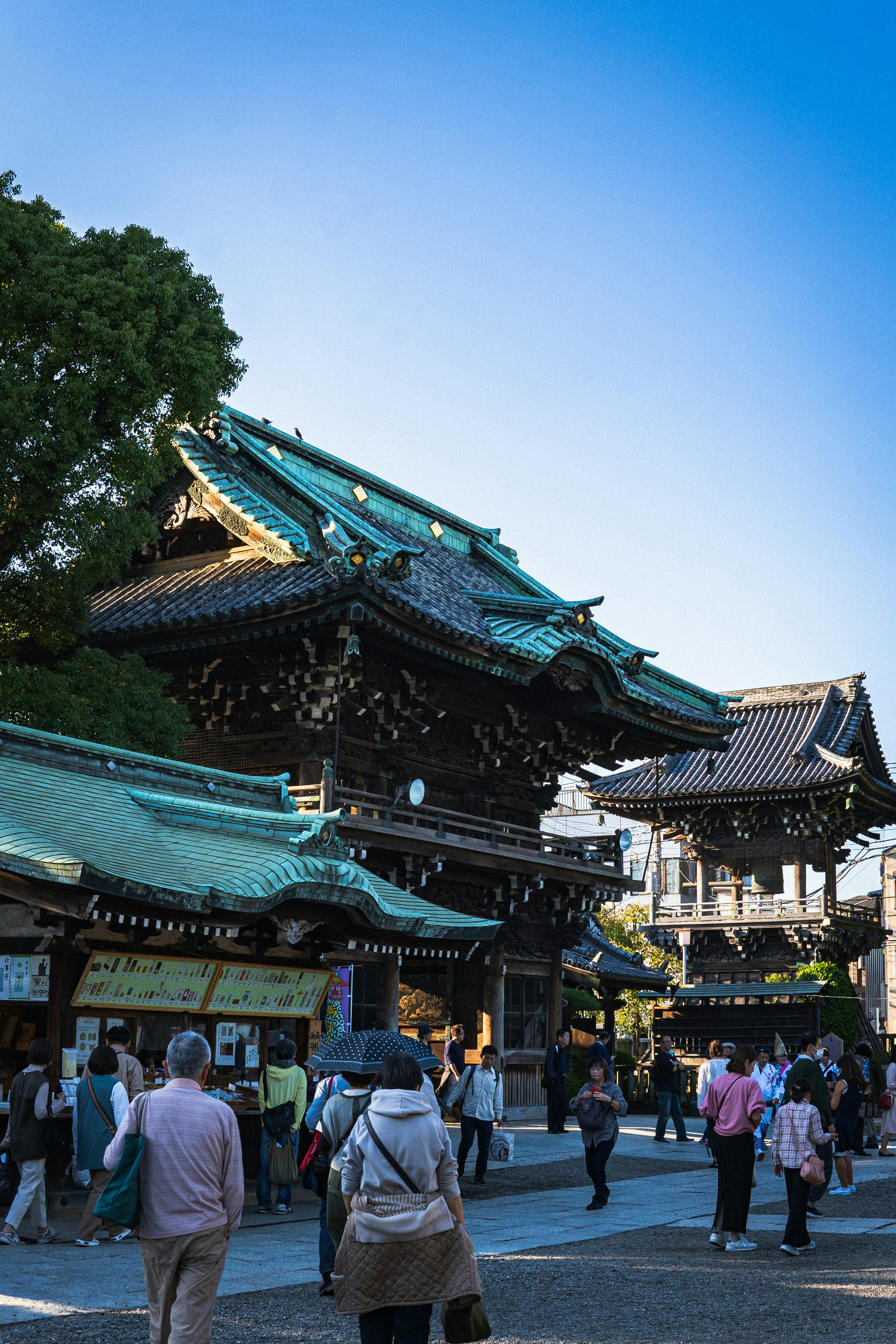 A group of people walking down a street next to tall buildings photo ...