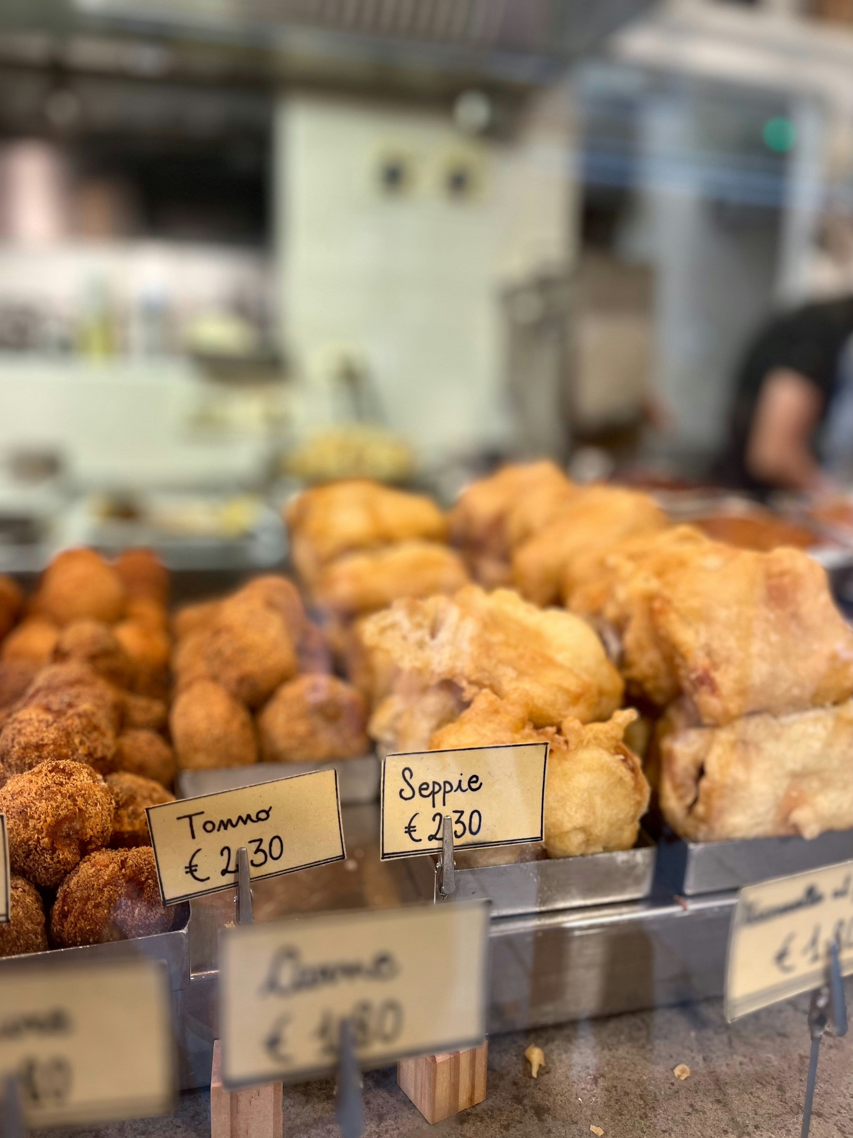 Center-Stage Crusts: Fried Pastries and Price Tags in a Bustling Bakery Display