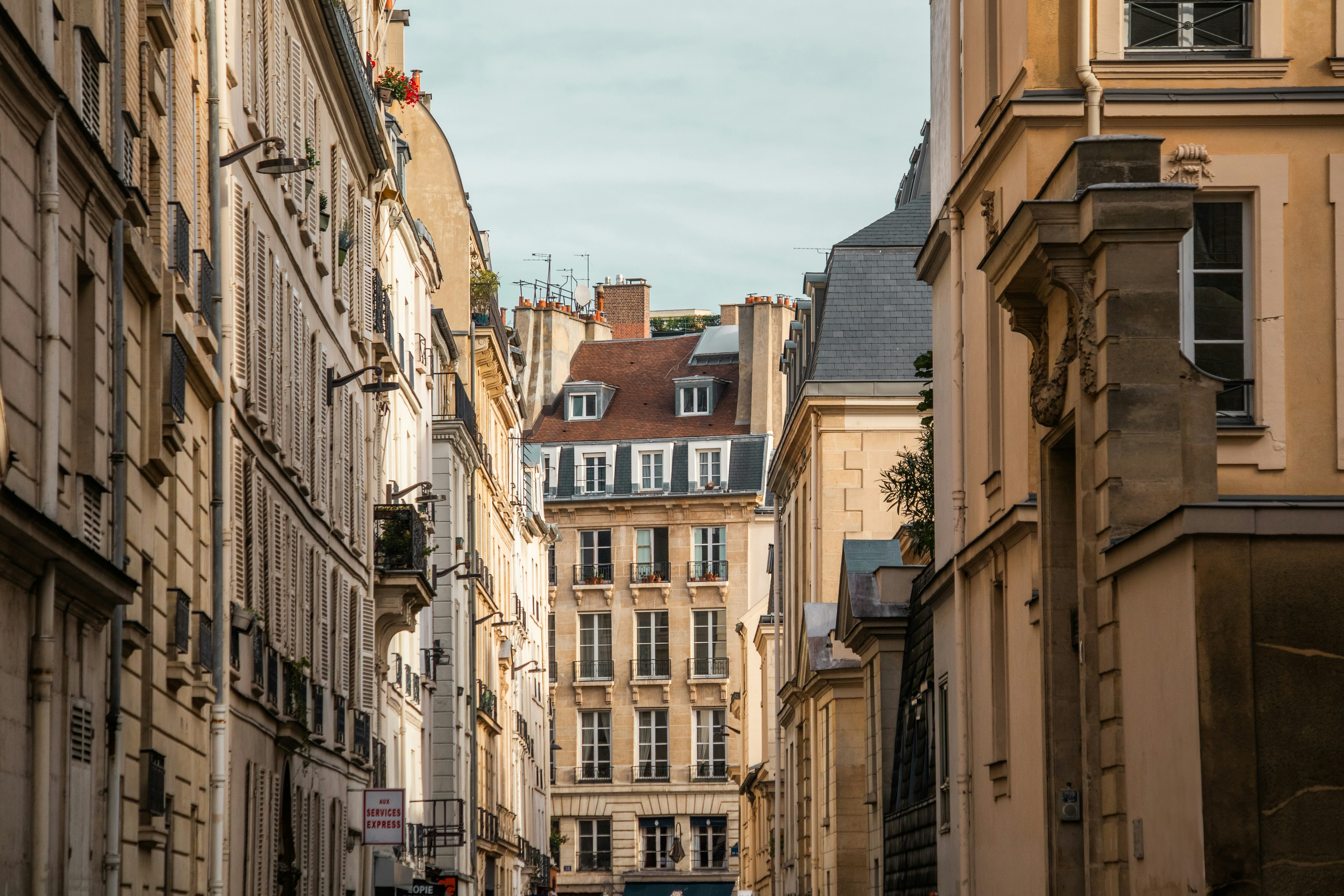 A narrow city street lined with tall buildings photo – Free Building ...