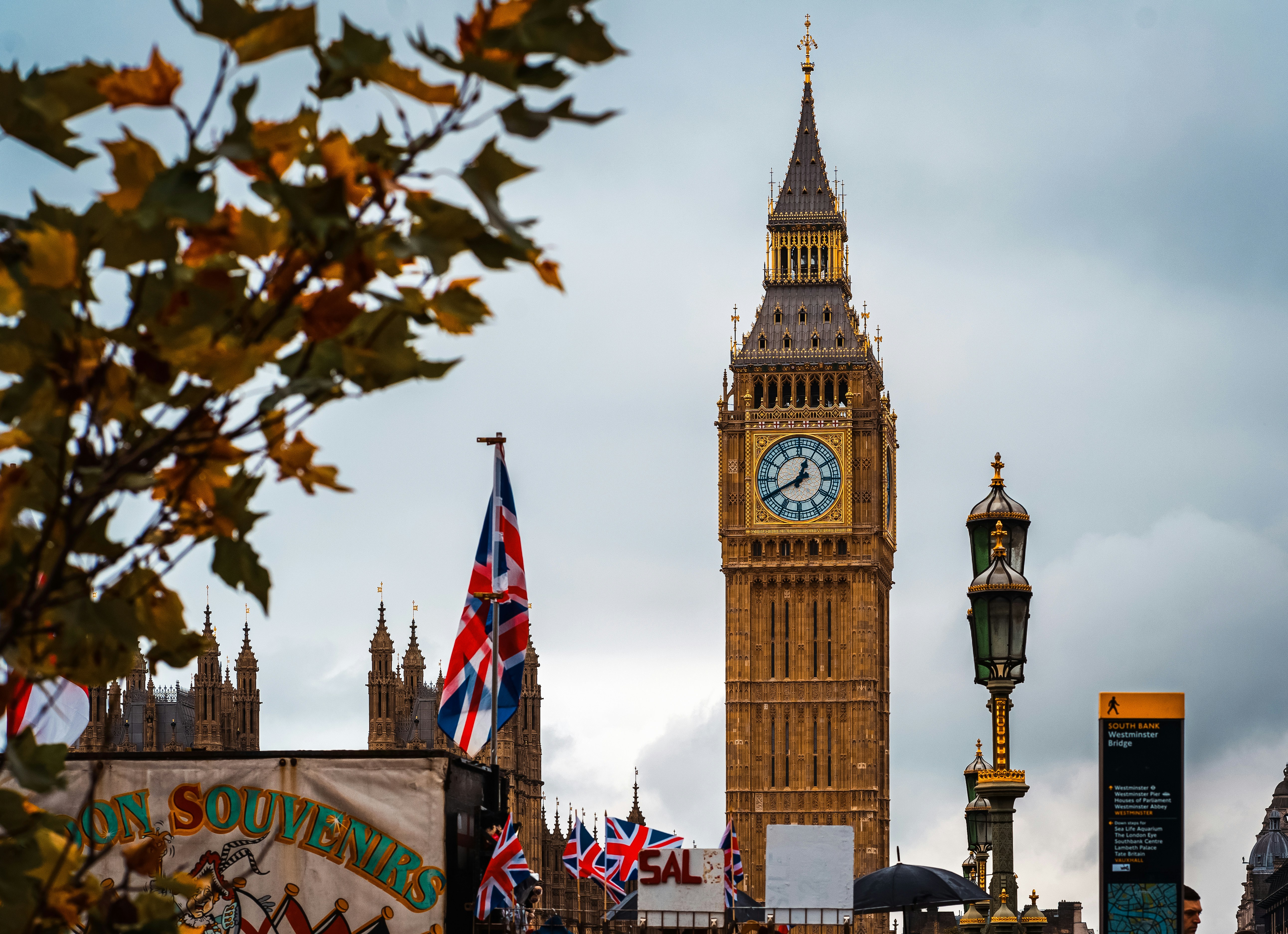 Big Ben on Market Day: Westminster Tower Framed by Autumn Leaves and Flags