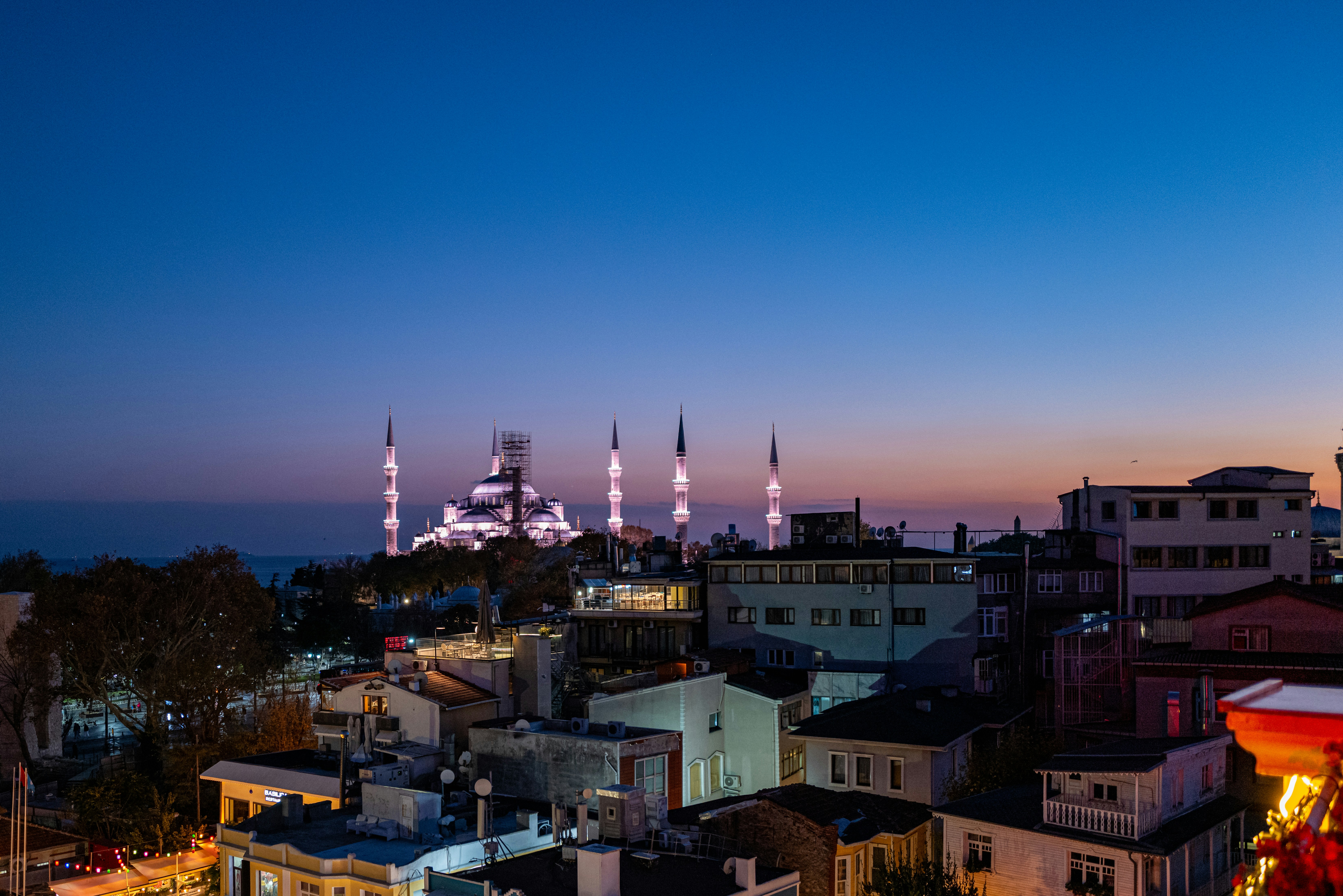 Horizon Minarets at Blue Hour: Mosque Silhouette Over a Lantern-lit City