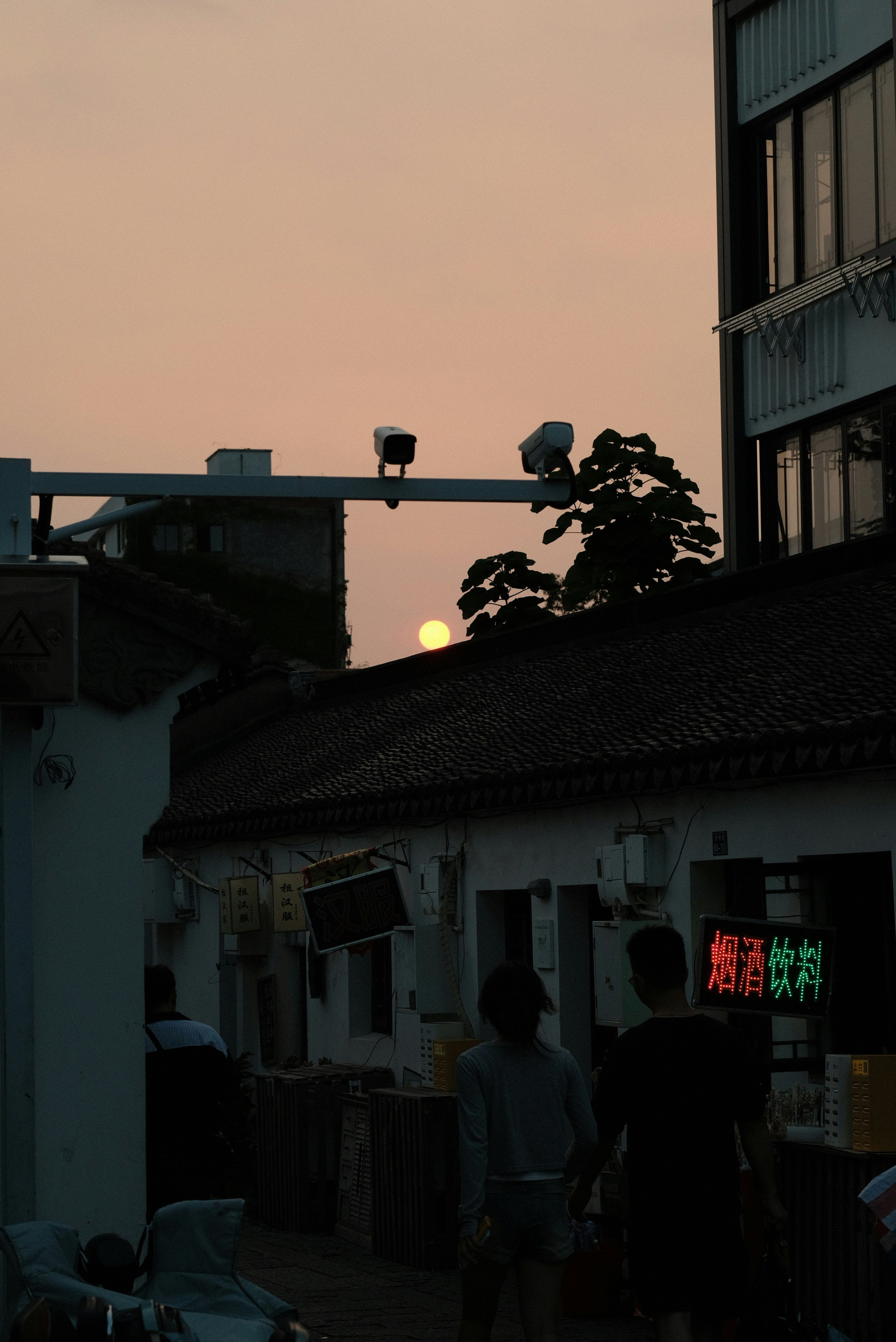 Dusk Over the Market Lane: Neon, Rooftops, and a Hidden Sun