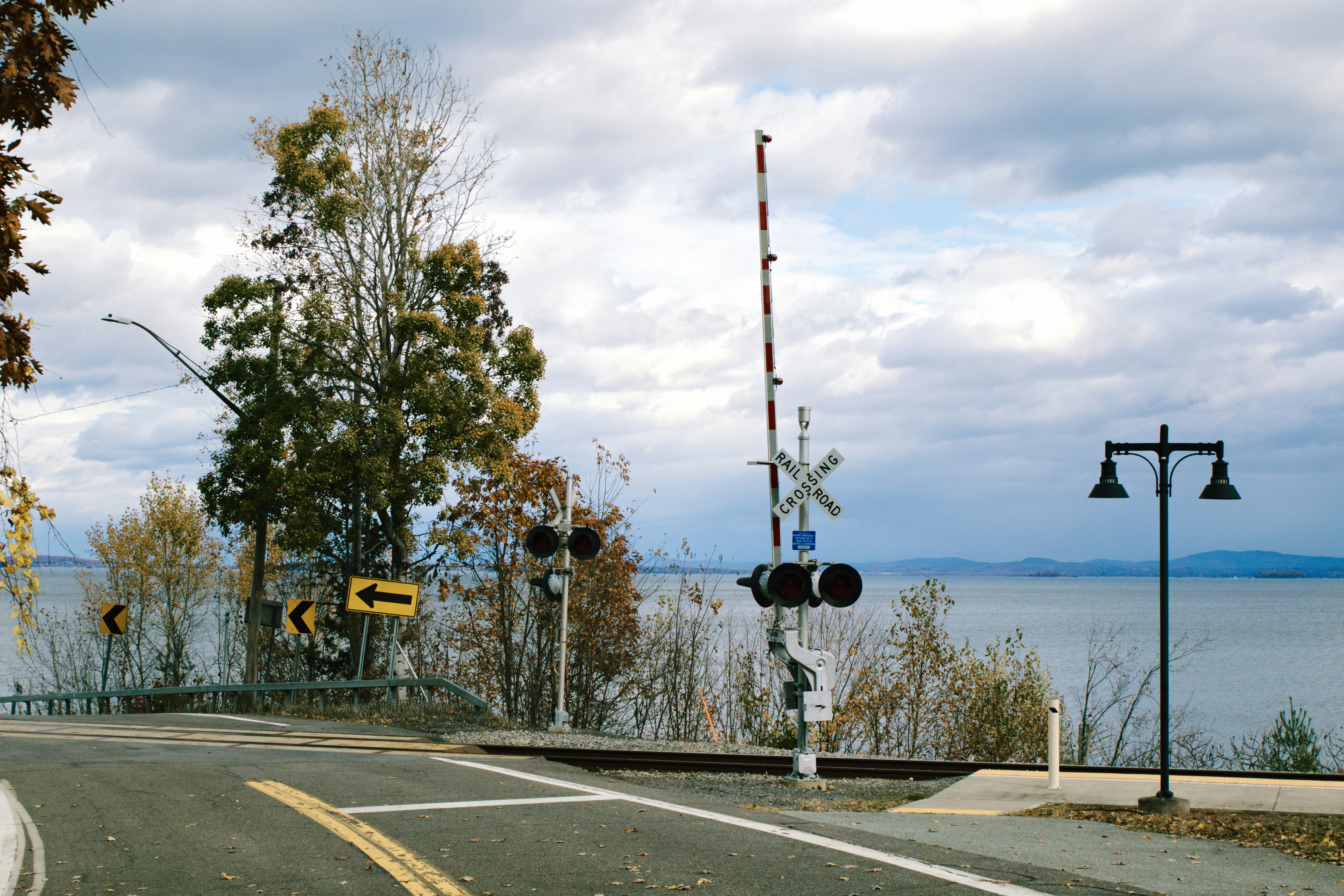 Railroad Crossing at a Calm Lakeside Curve