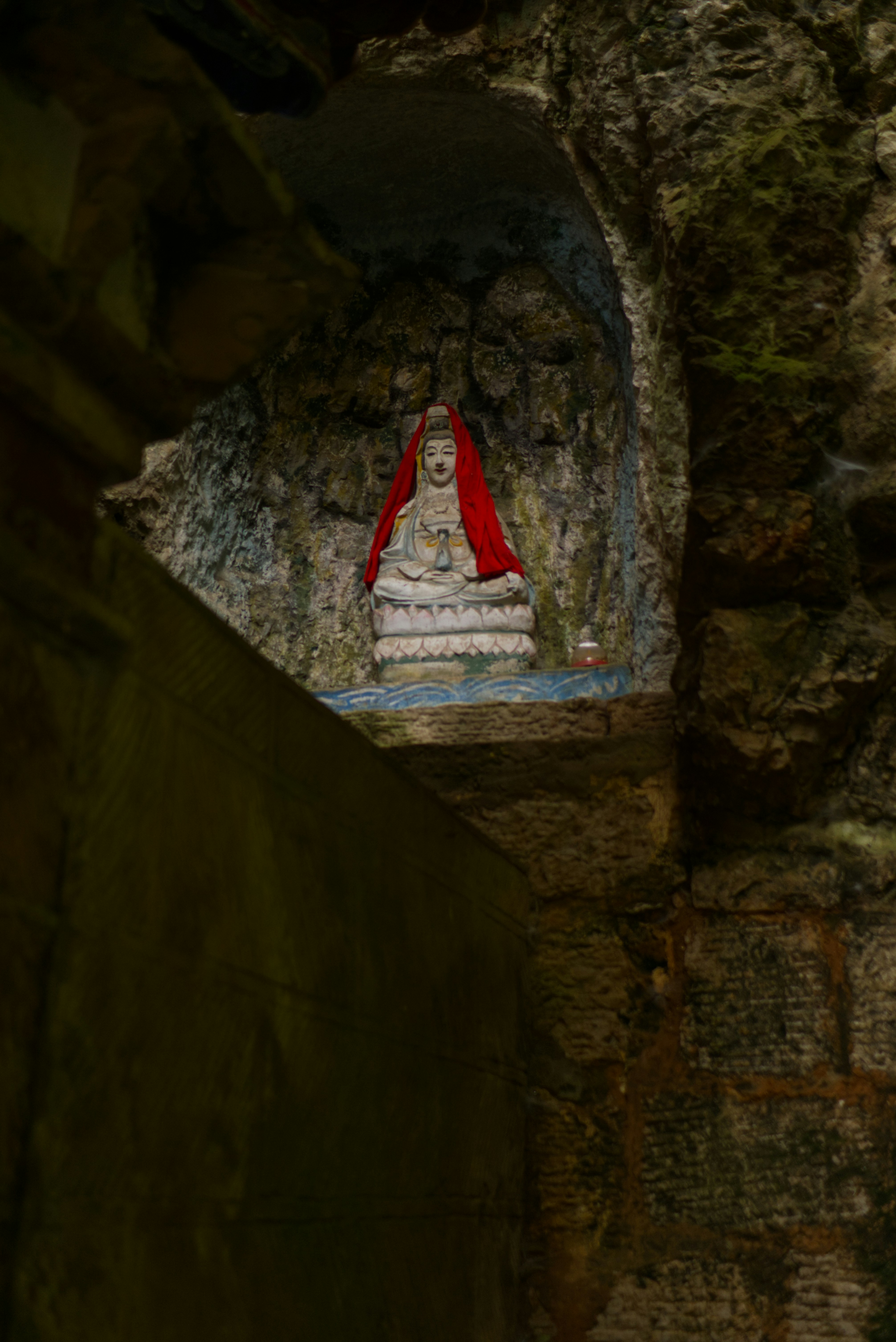 Red Veil Buddha in a Quiet Cliff Shrine