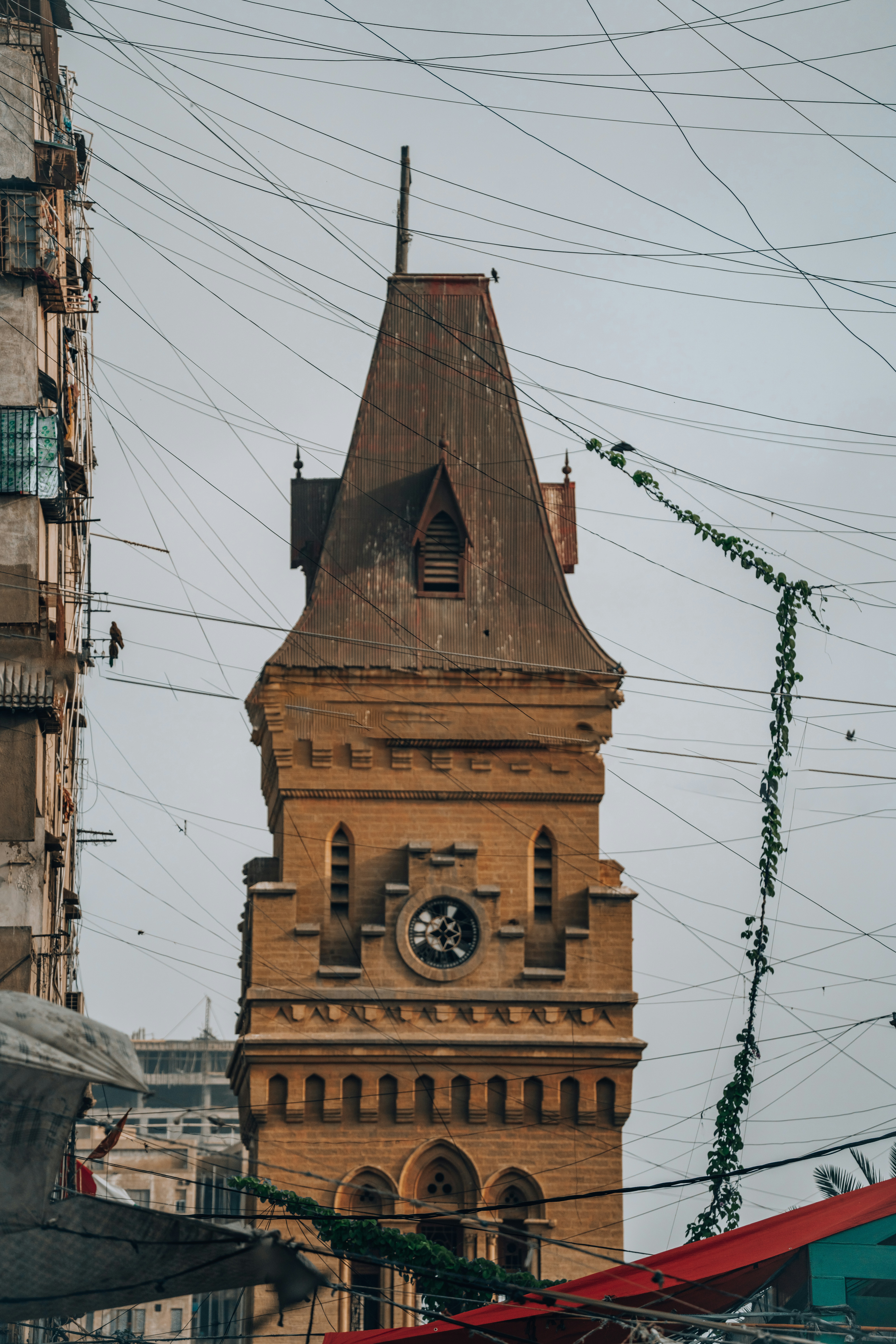 Clocktower Framed by a Web of Wires in a Narrow City Vista
