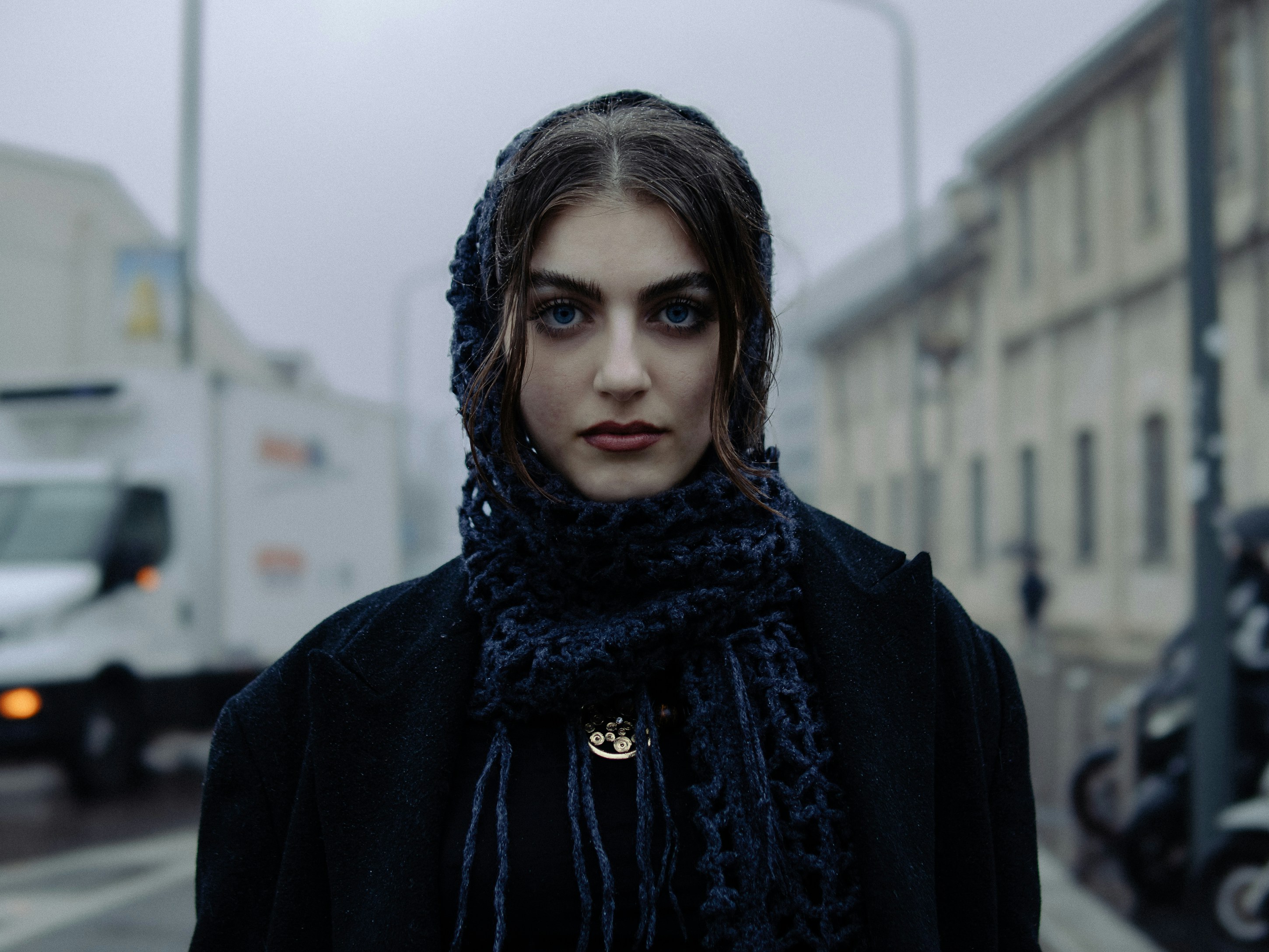 Gaze Under Steel Skies: Portrait on a Rain-Slick City Street
