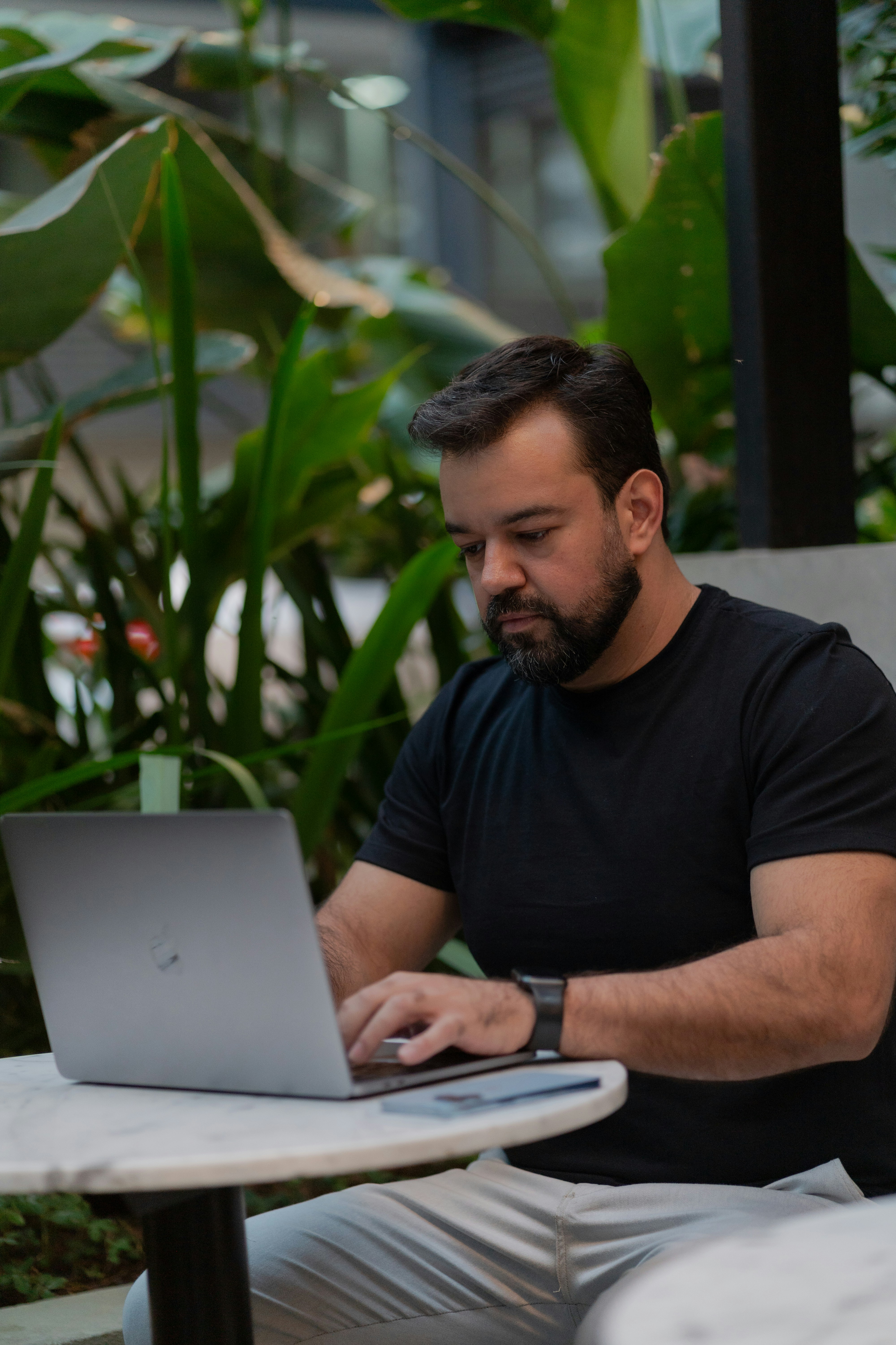 A man sitting at a table using a laptop computer photo – Free Man Image ...