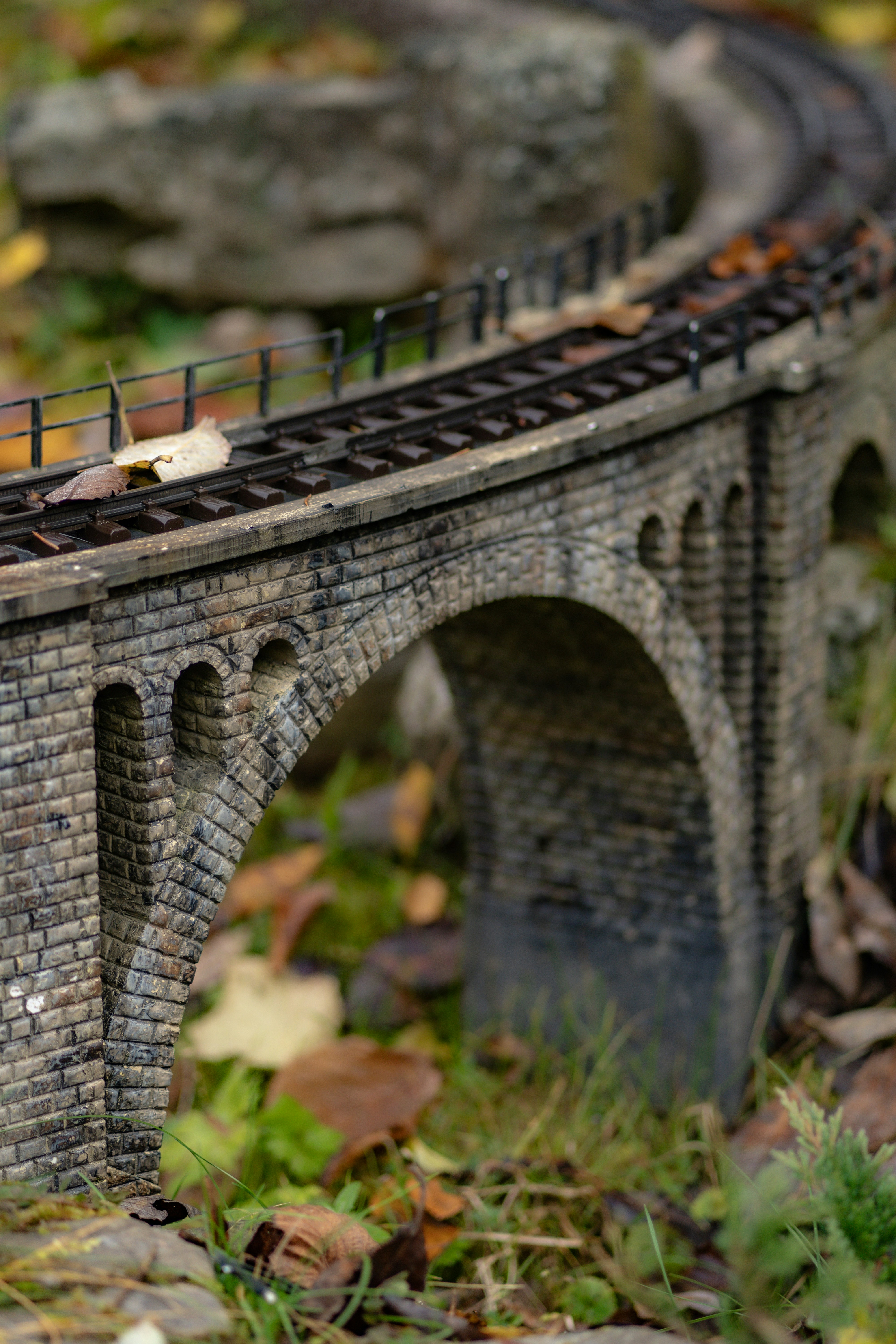 Autumn on a Miniature Bridge: Rails Across a Stone-Arch Marvel
