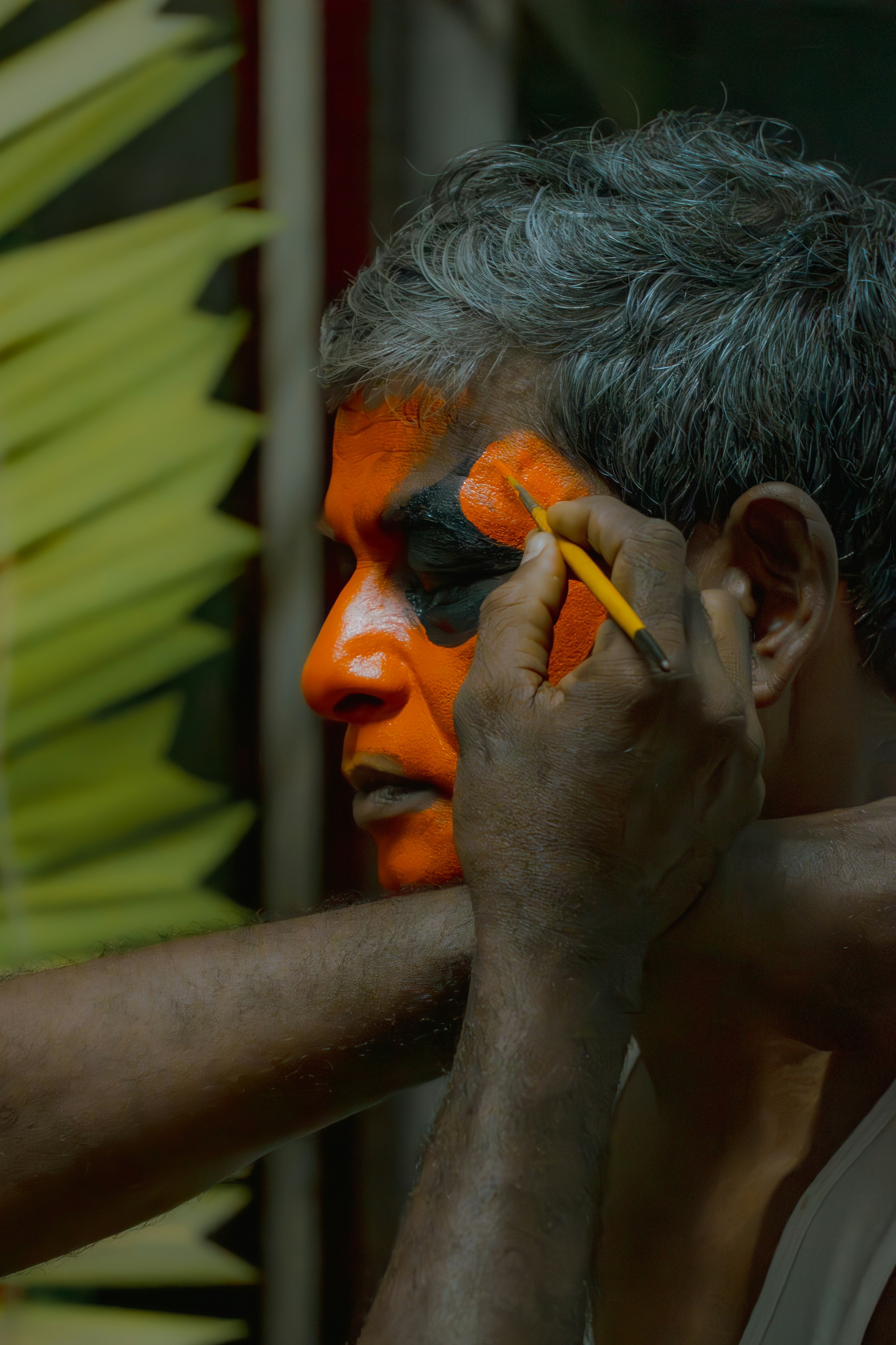 A man getting his face painted with orange photo – Free Tripunithura ...