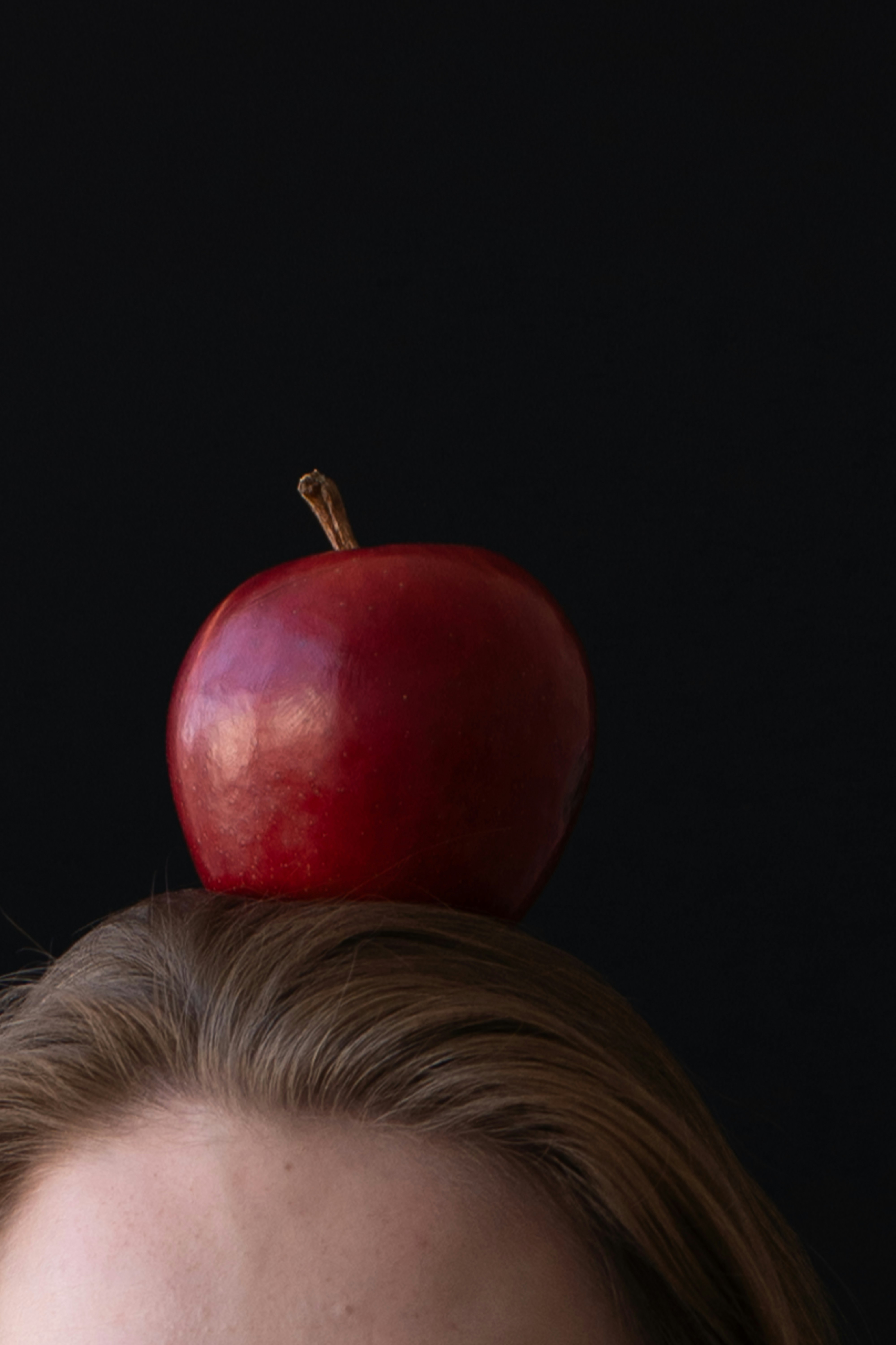 A woman with a red apple on top of her head photo – Free Girl Image on ...
