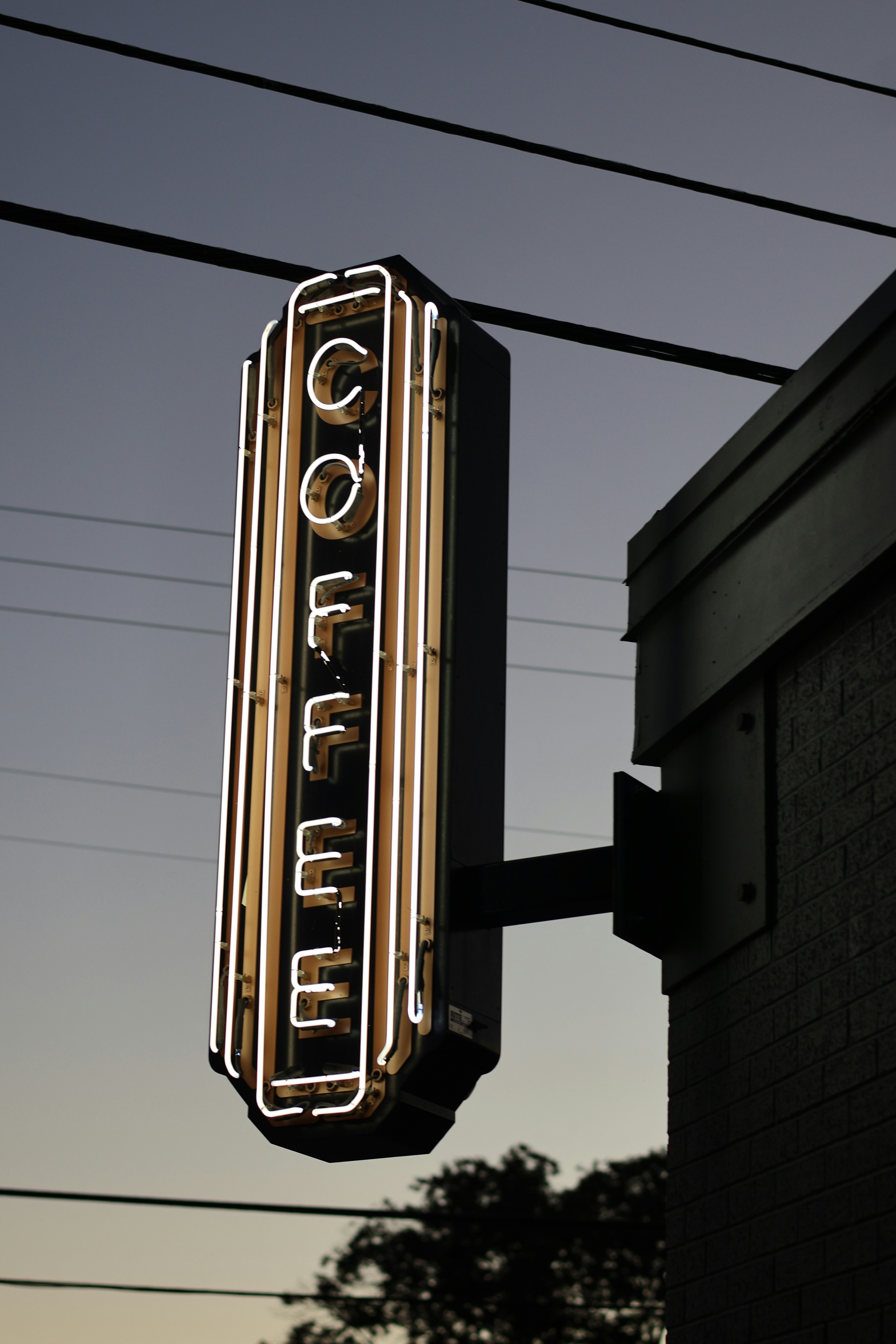 A neon sign that is on the side of a building