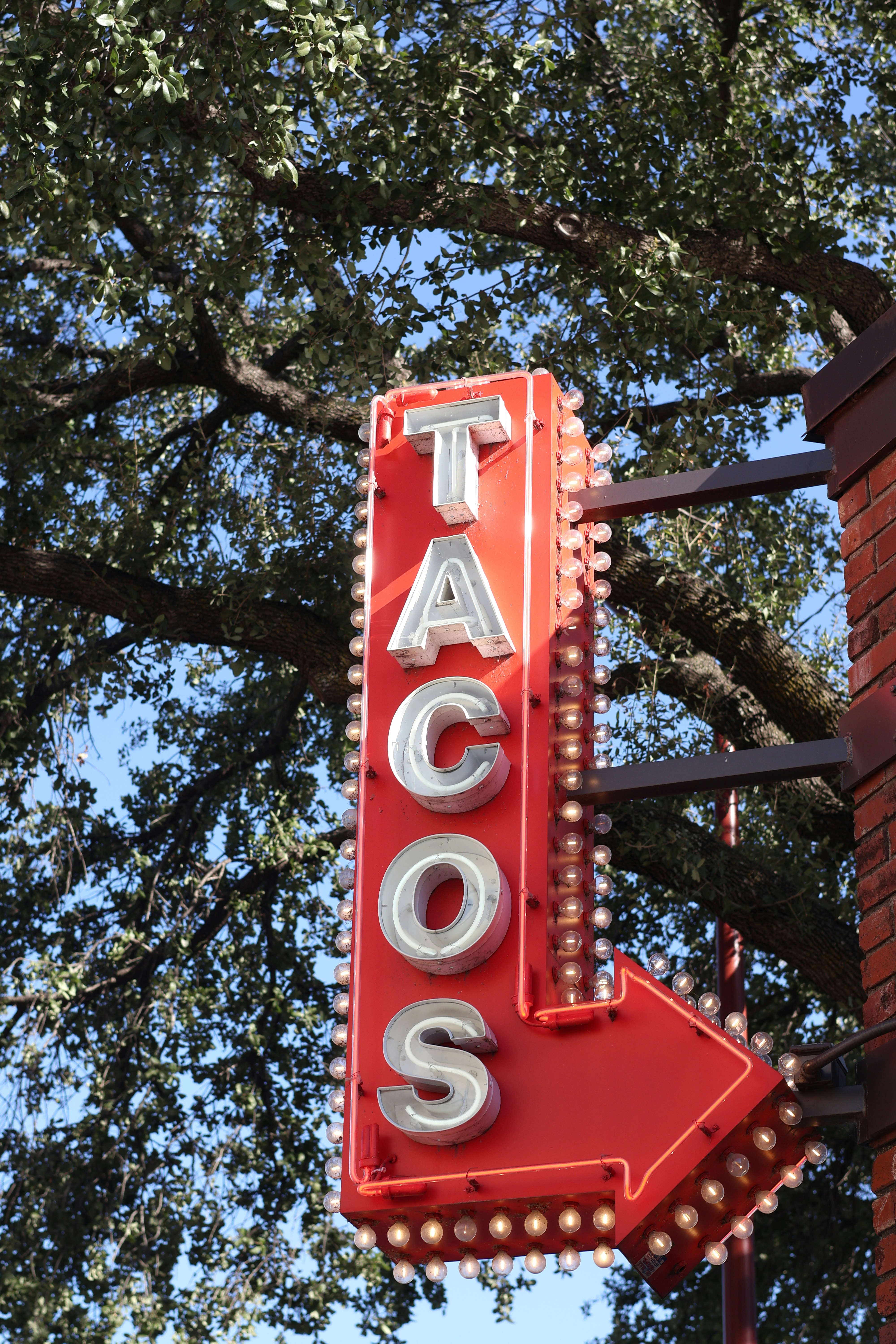 Un letrero de tacos rojos colgado del costado de un edificio foto ...