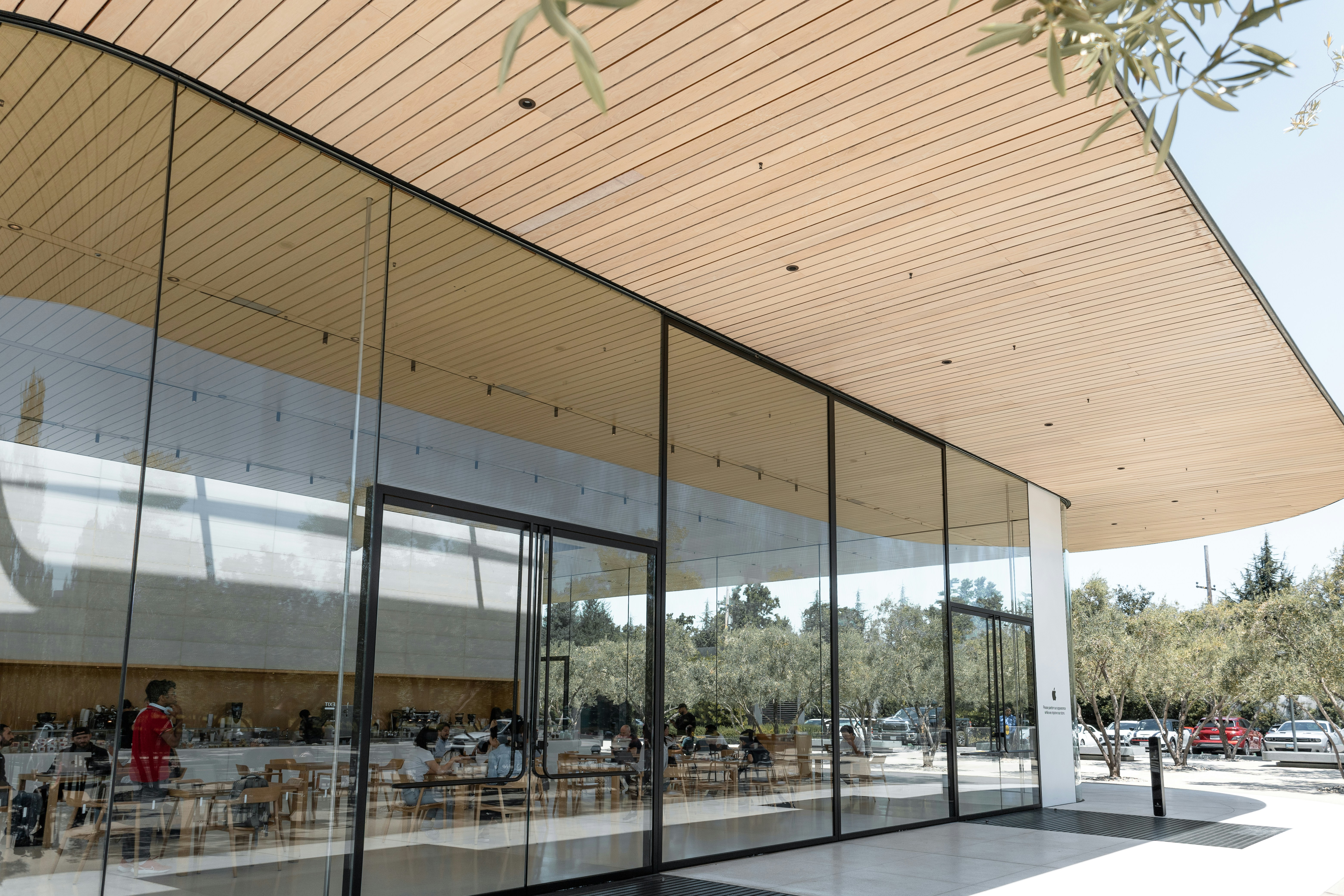 A large glass building with people eating outside