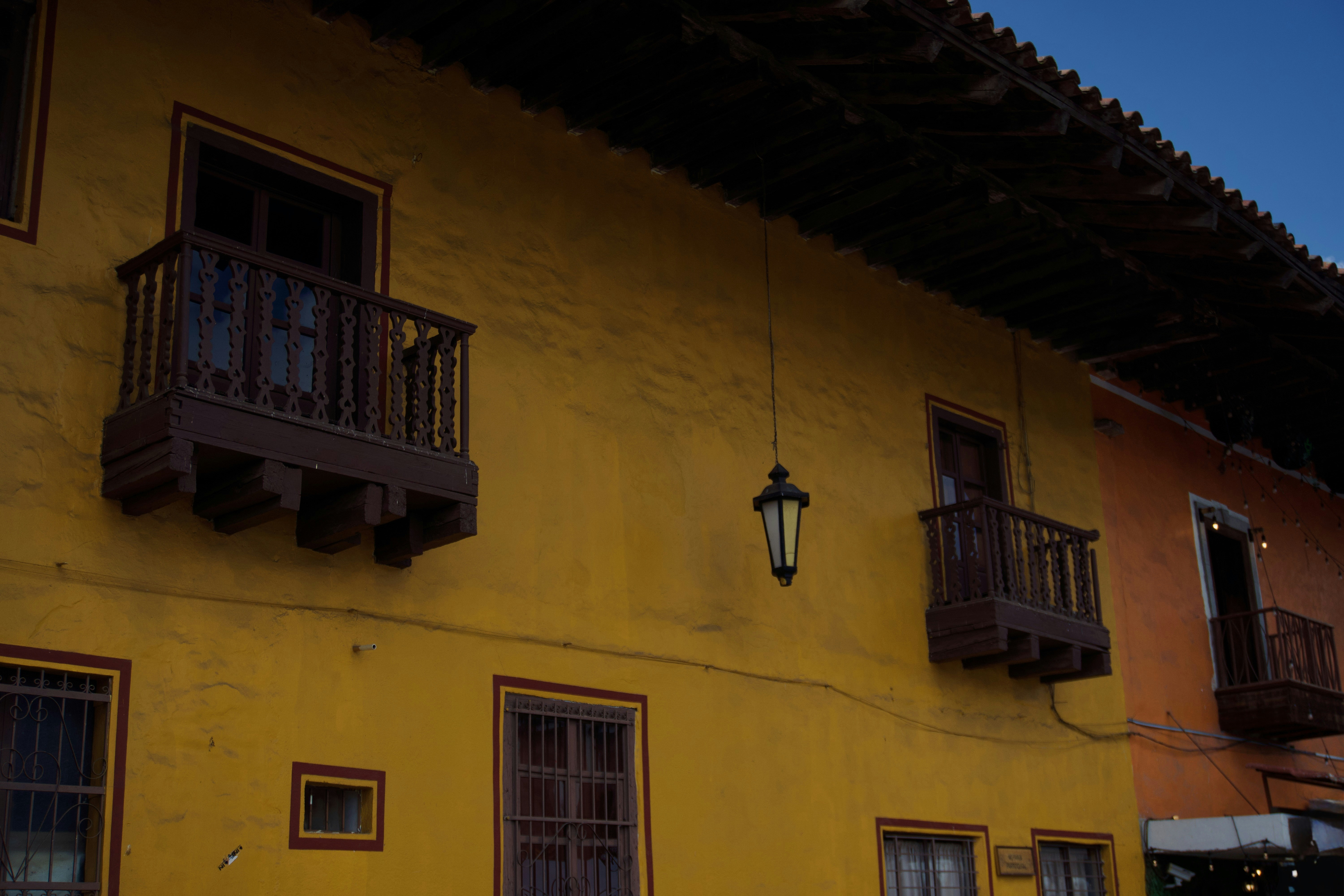 Lantern Between Balconies on a Sunlit Yellow Facade