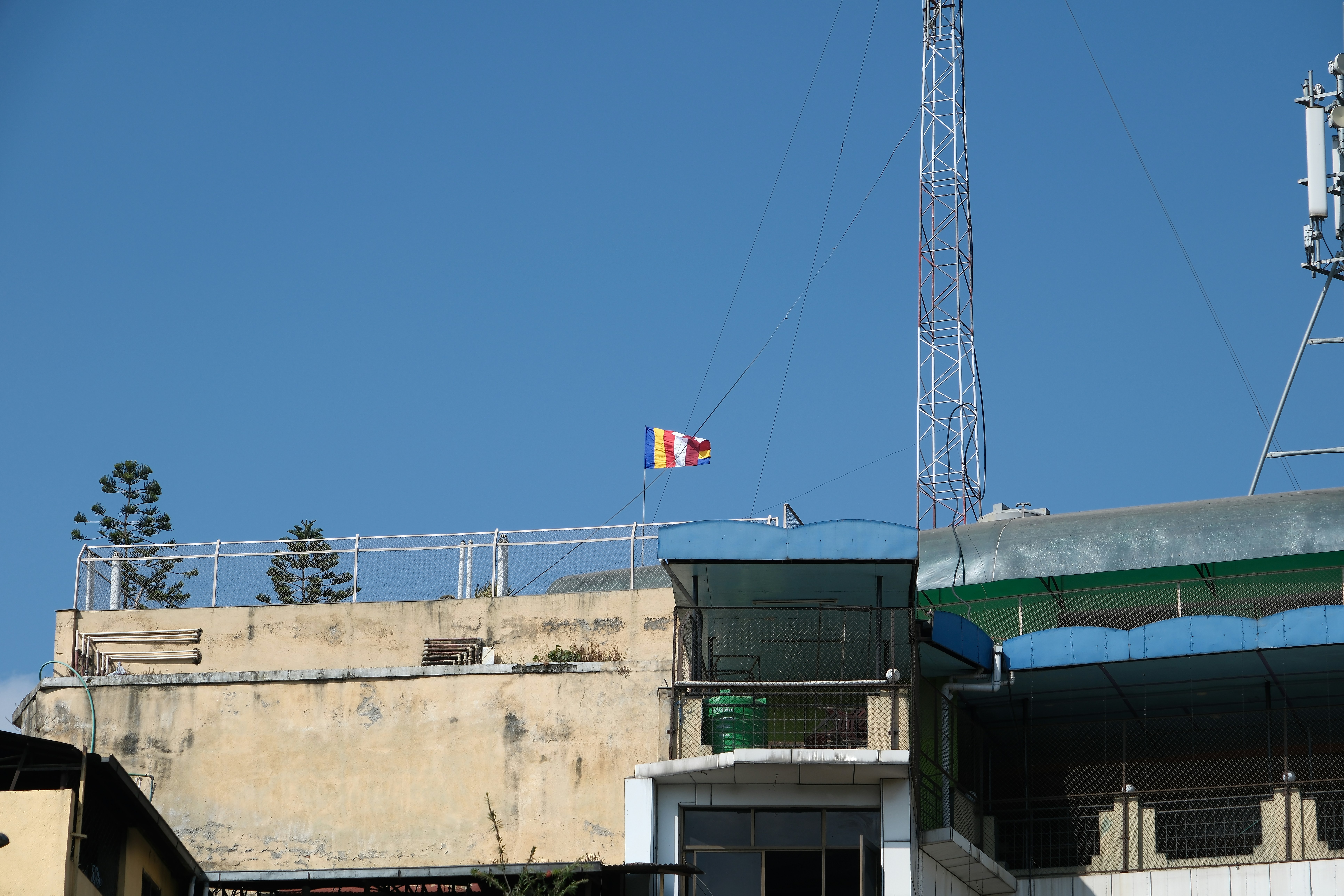 Flag on the Rooftop Edge, Under a Cobalt Sky