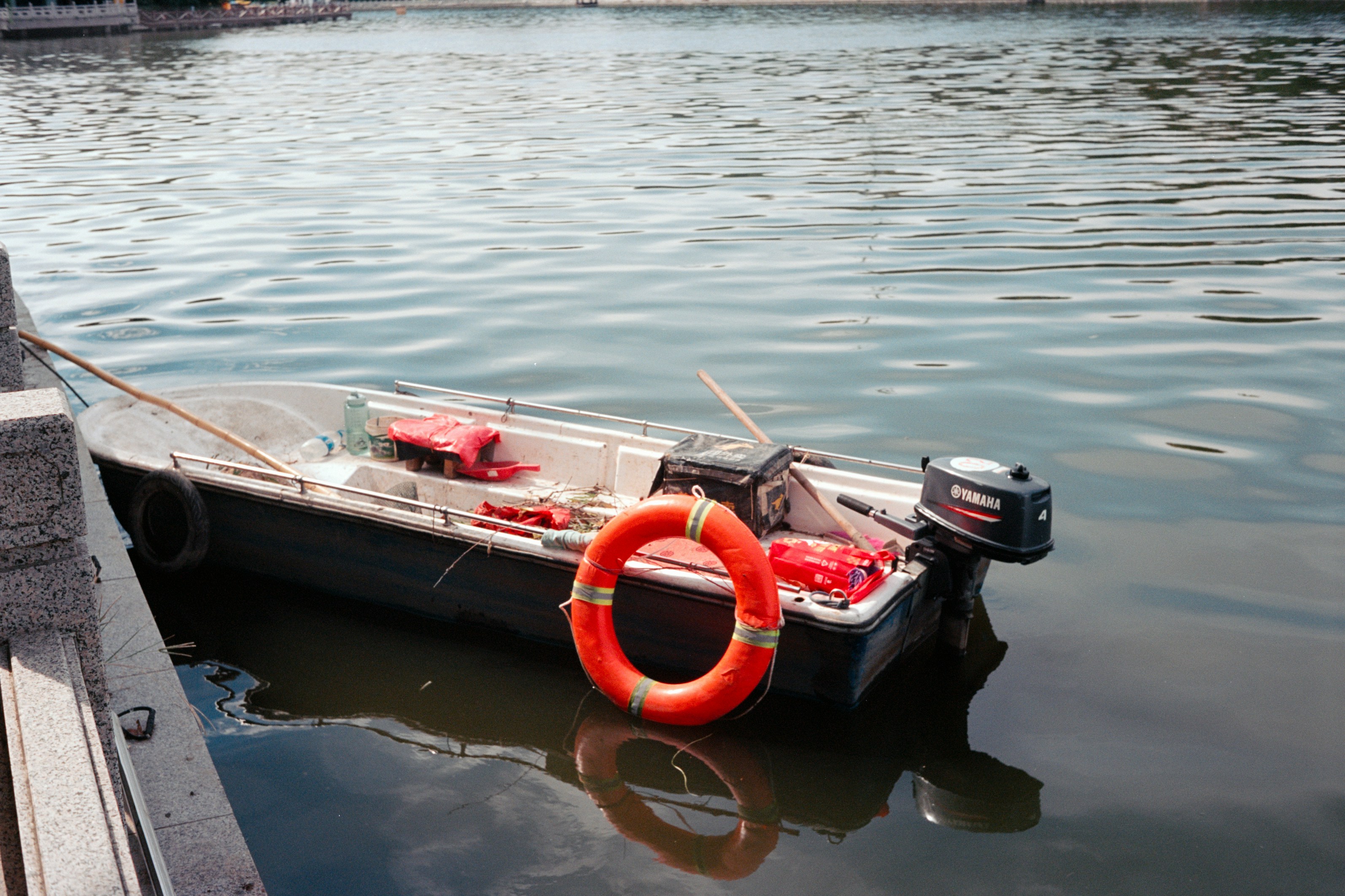 A small boat tied to a dock with a life preserver photo – Free Vehicle ...