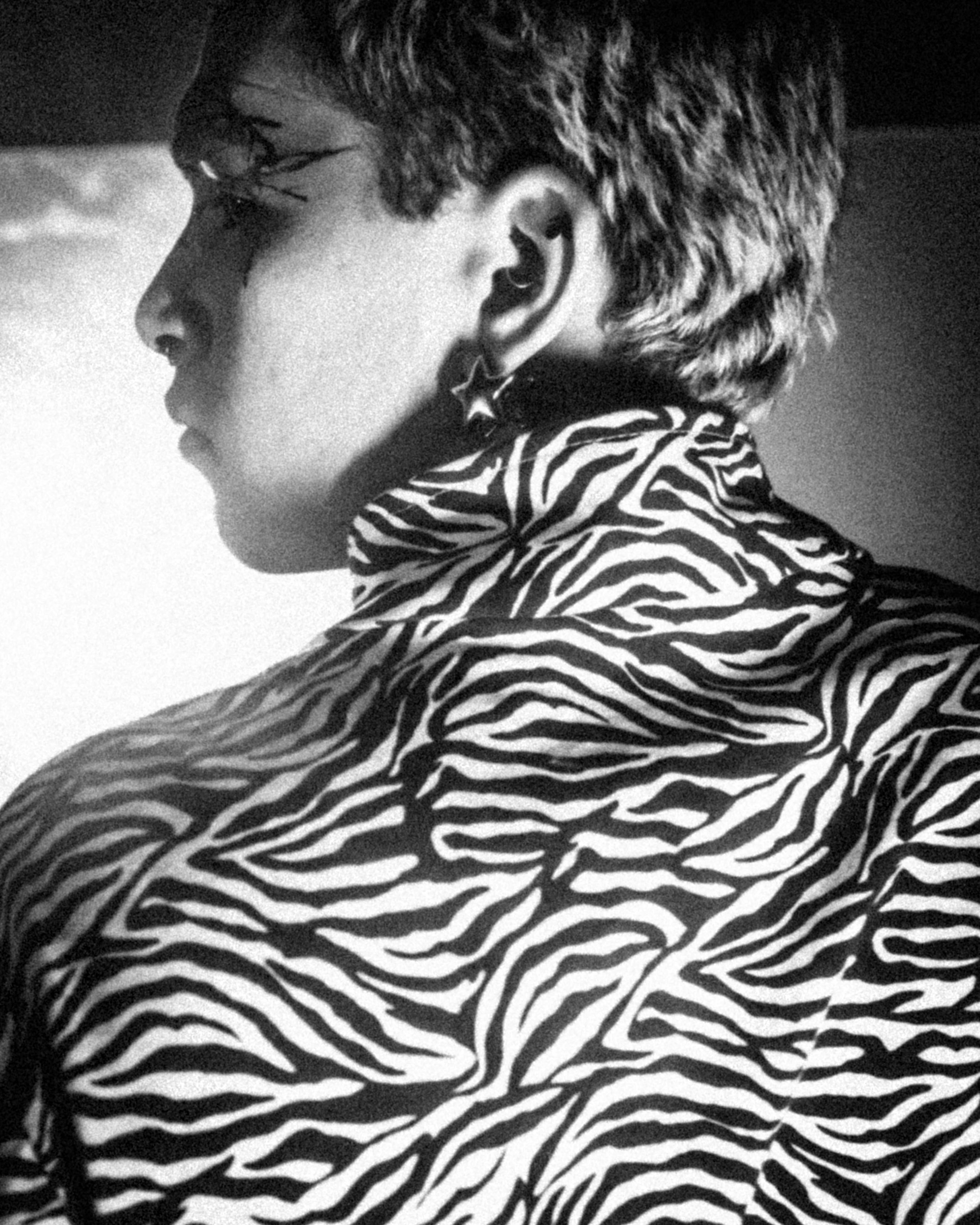 A woman in a zebra print shirt looking off into the distance photo ...