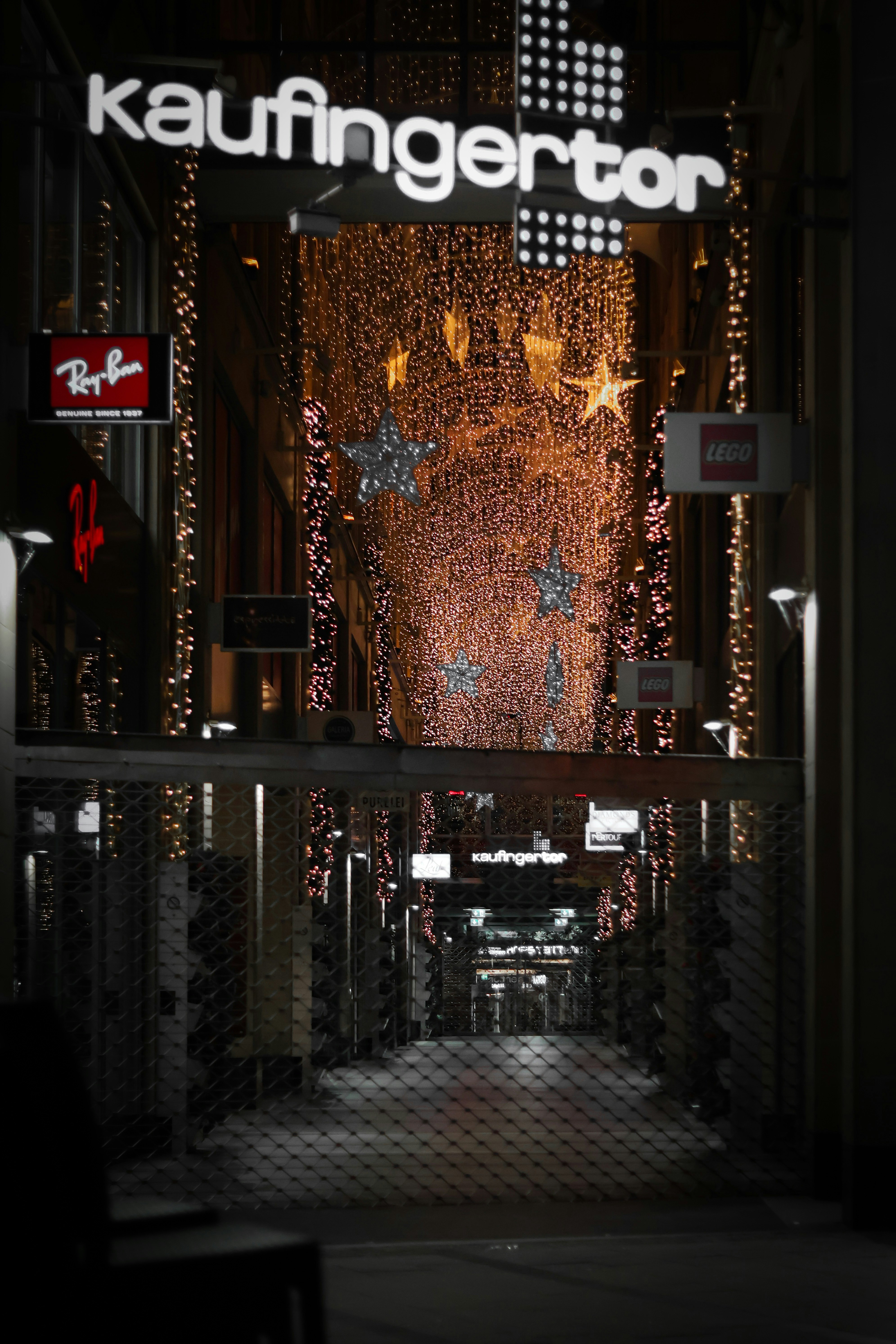 Neon Stars Over a Gate-Lined Night Corridor