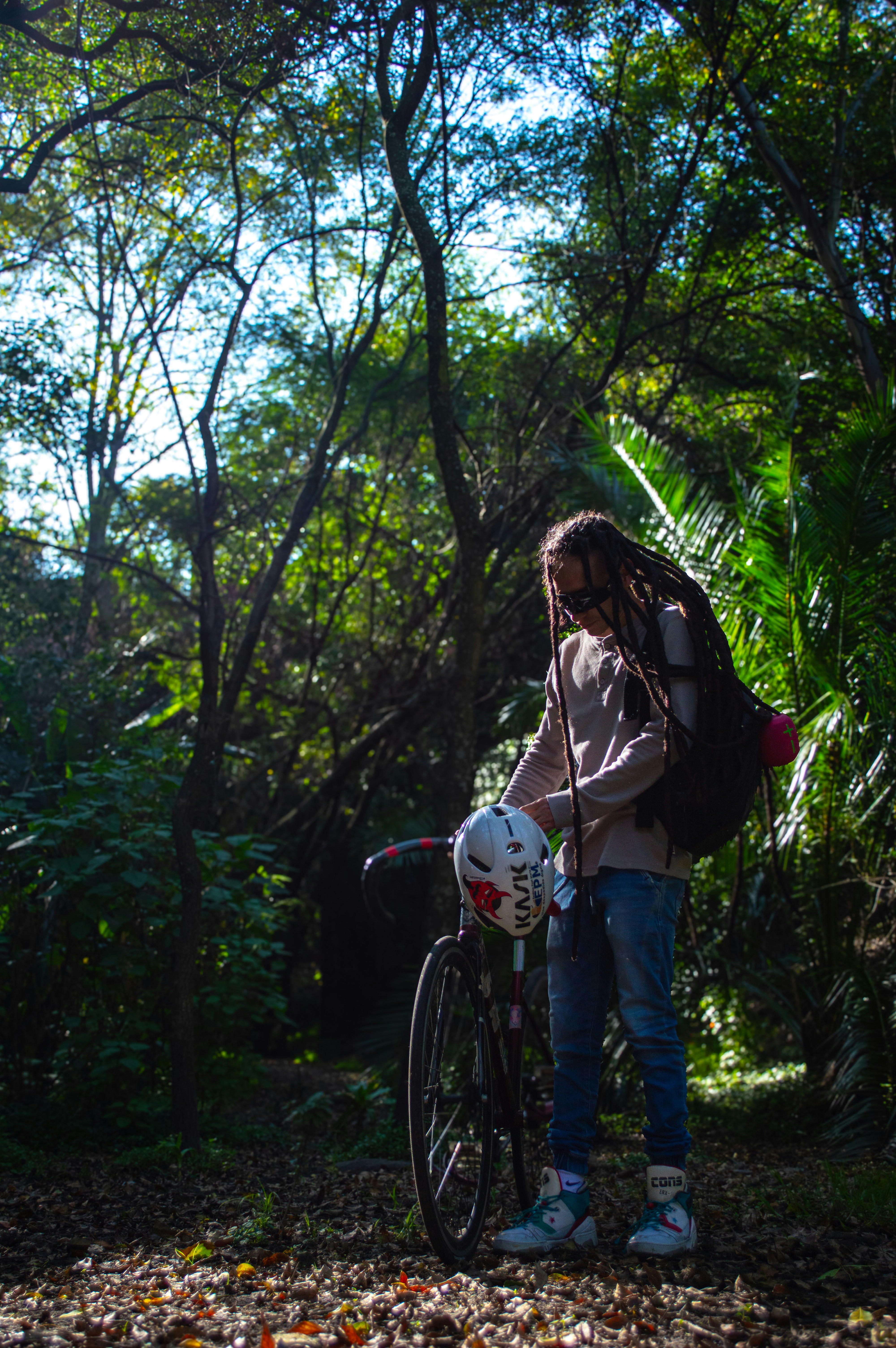 Pedal through the Fern Guinness: a rider checks the bike on a sunlit forest trail