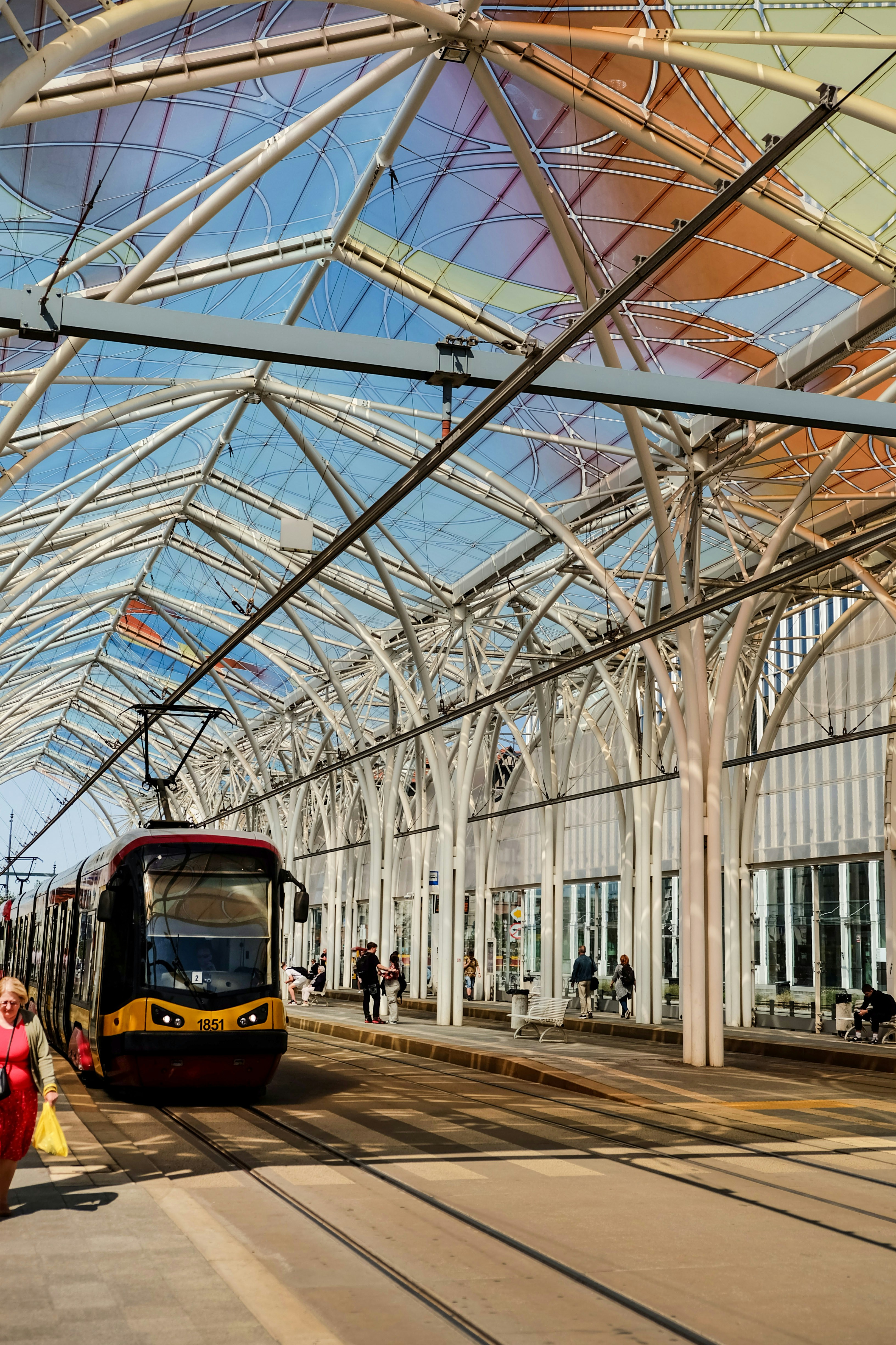 Crimson Tram Beneath a Kaleidoscopic Glass Canopy
