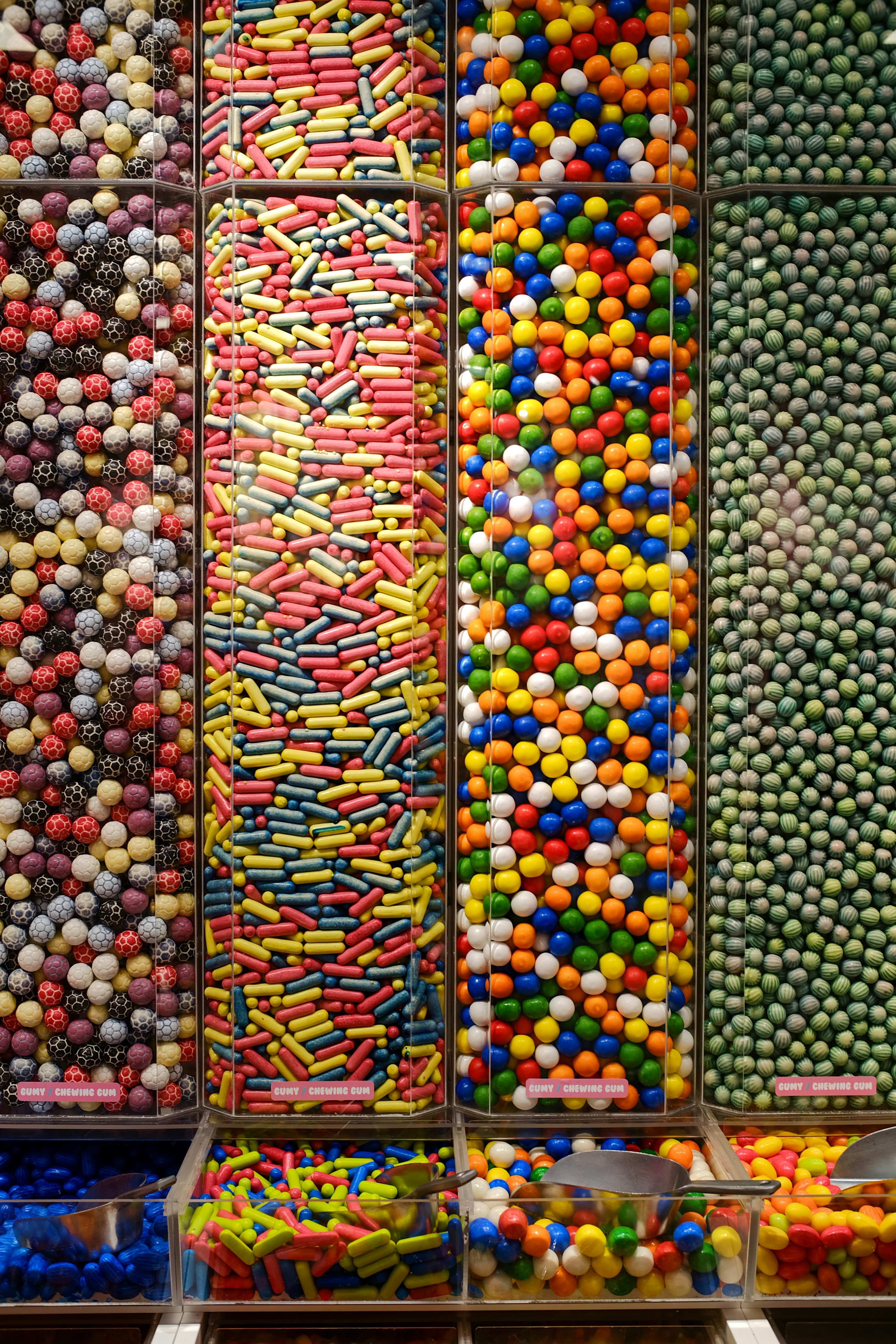 A display case filled with lots of different colored candies photo ...