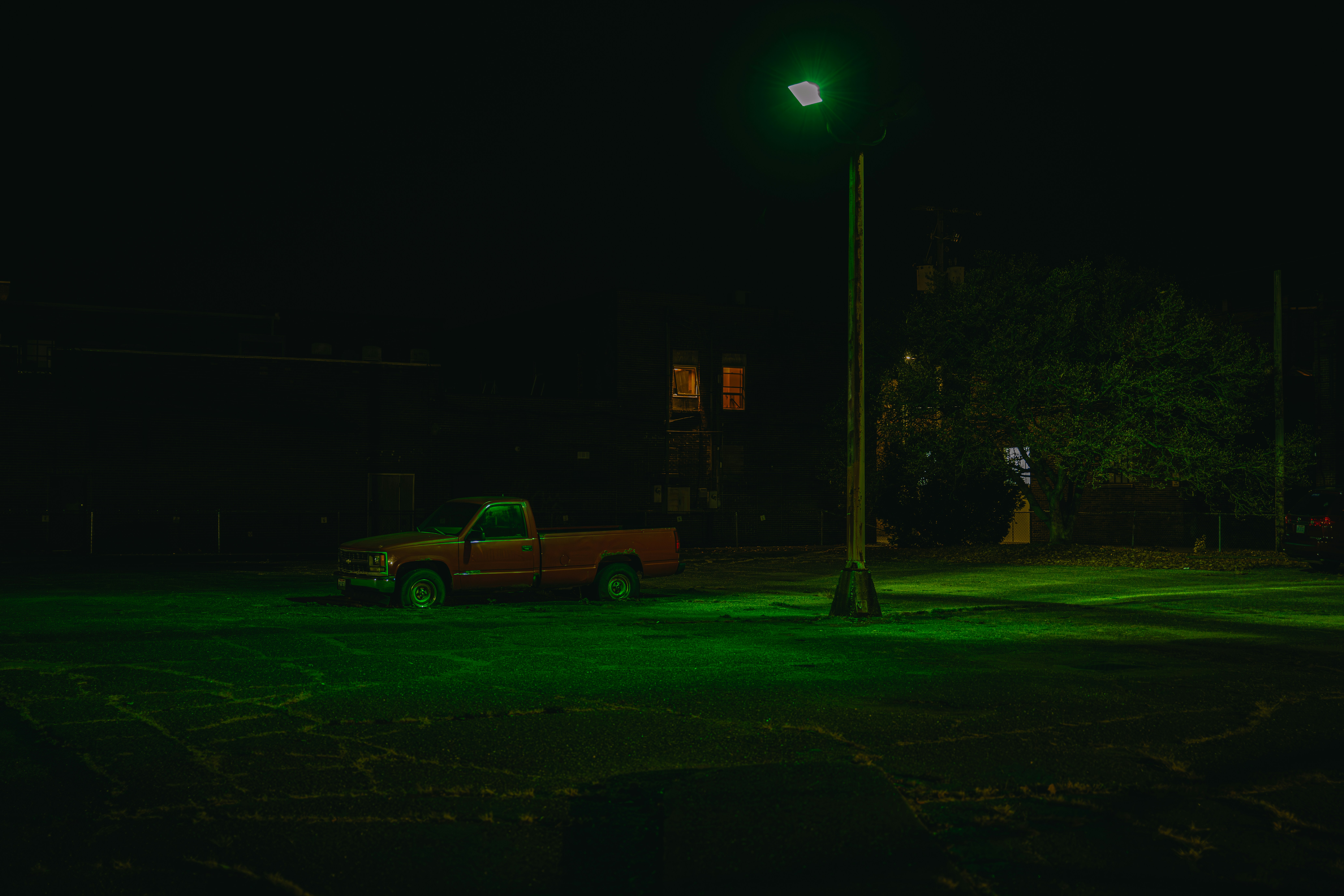 Emerald Hour: A Lone Streetlamp Illuminates a Quiet Parking Lot